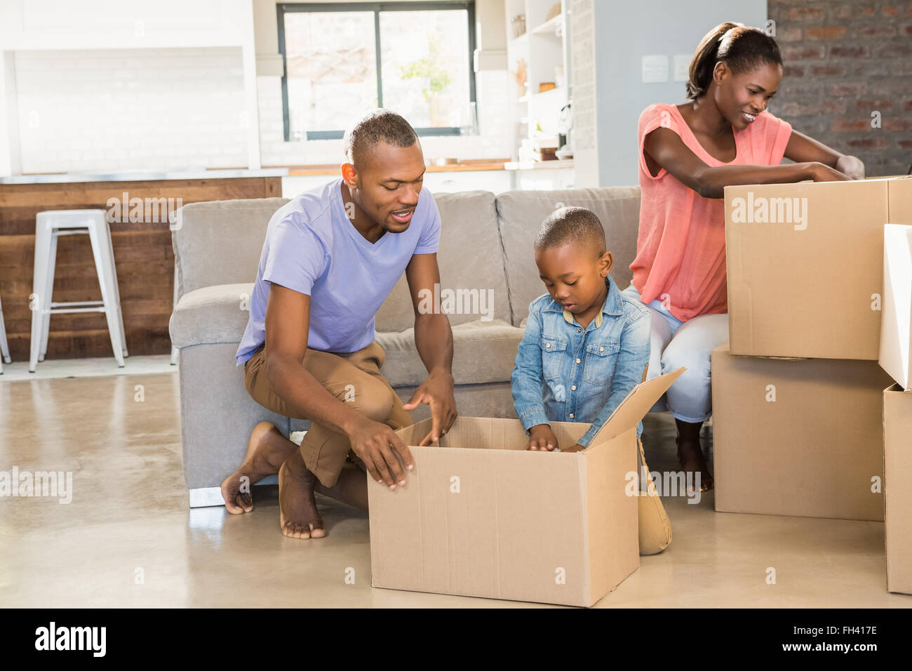 Family unwrapping things in new home Stock Photo - Alamy