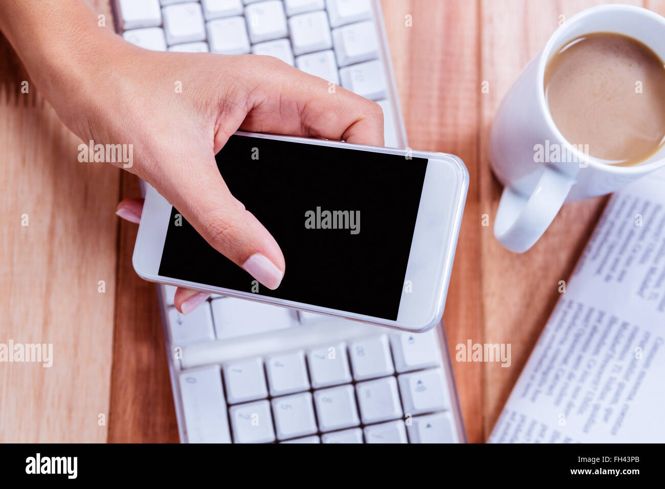 Businesswoman using her smartphone on desk Stock Photo - Alamy