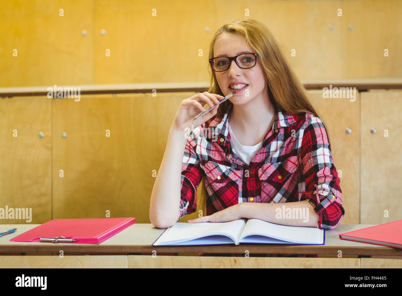 Smiling student sitting at her desk Stock Photo - Alamy