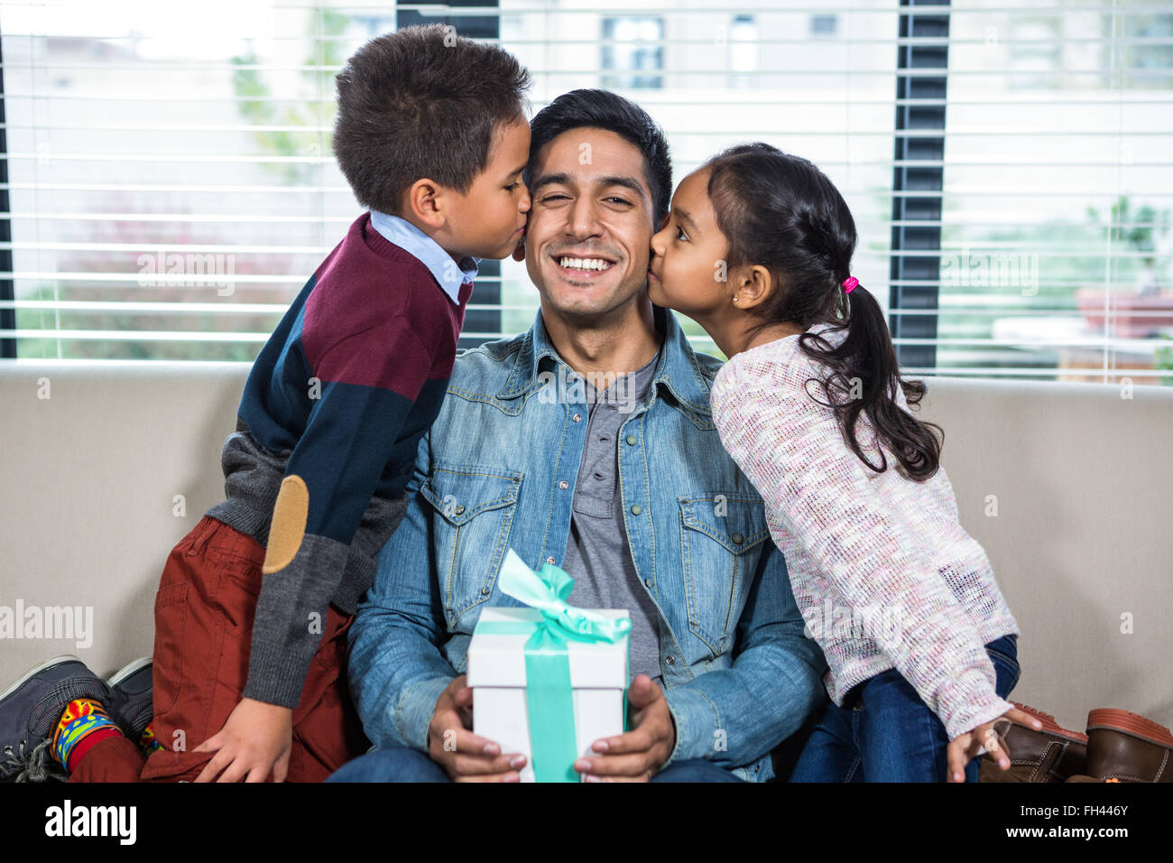Happy father receiving a gift from his children Stock Photo - Alamy