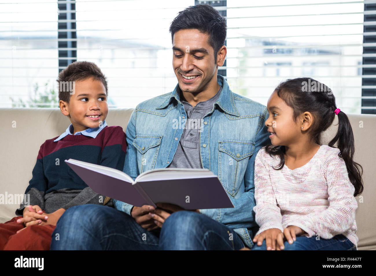 Happy father reading a book for his children Stock Photo - Alamy