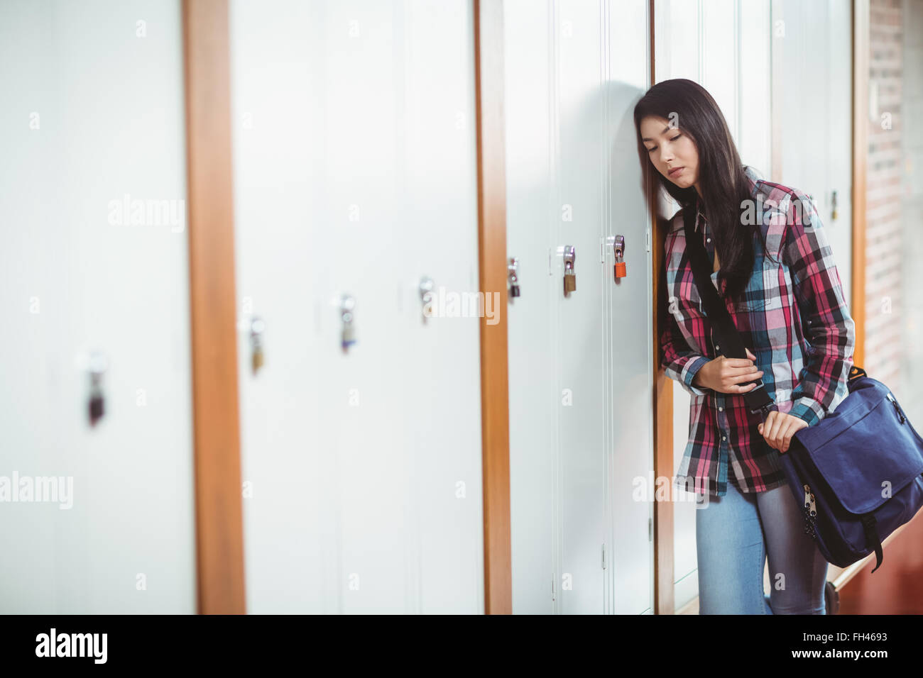 Restless student standing next the locker Stock Photo - Alamy