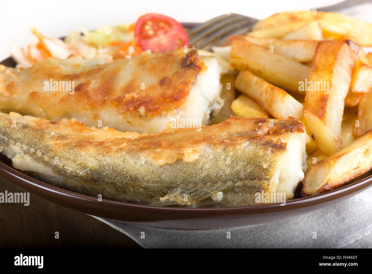 fried fish - saffron cod with potatoes and vegetables Stock Photo - Alamy
