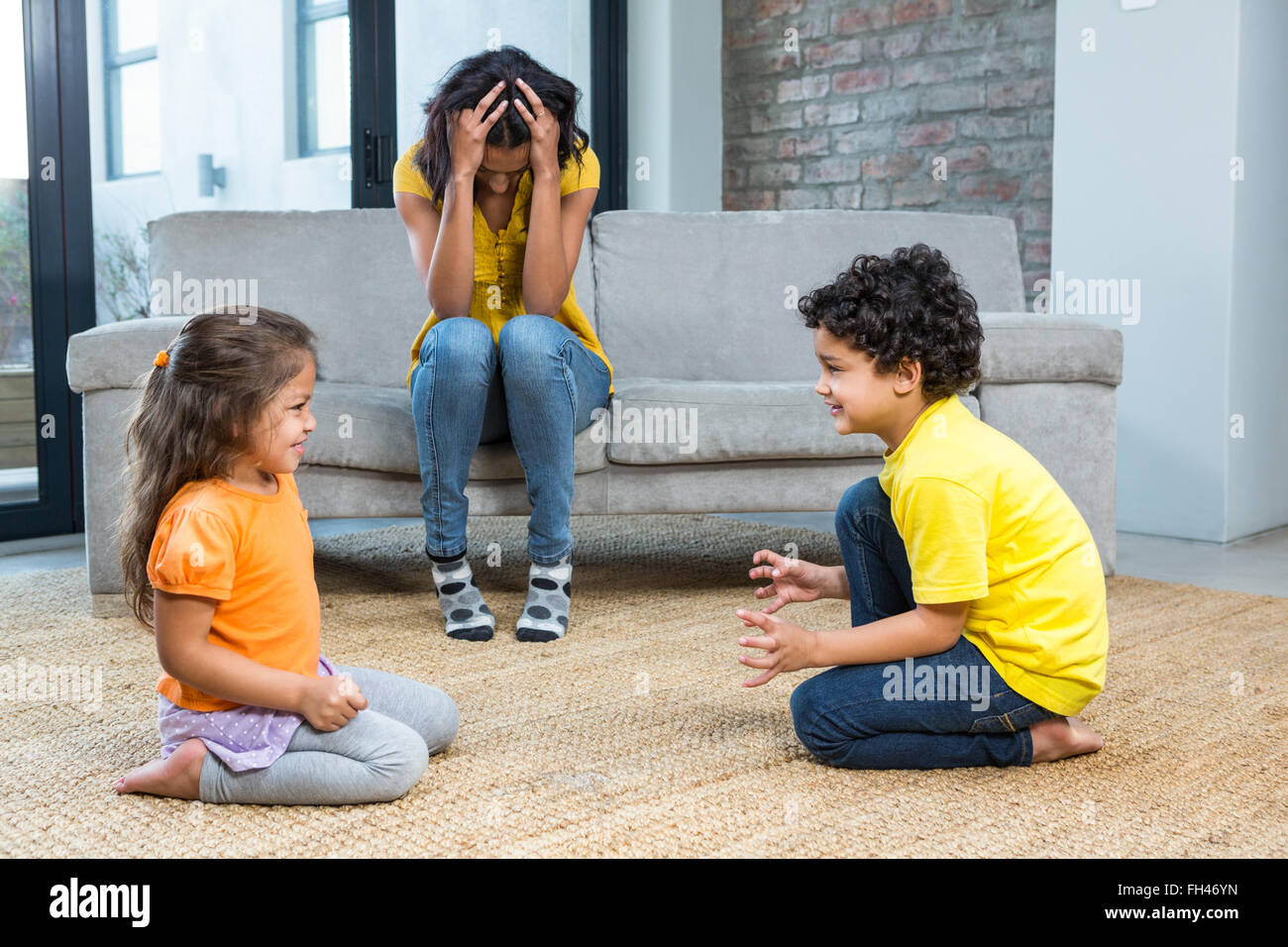 Fed up mother listening to her young children fight Stock Photo - Alamy