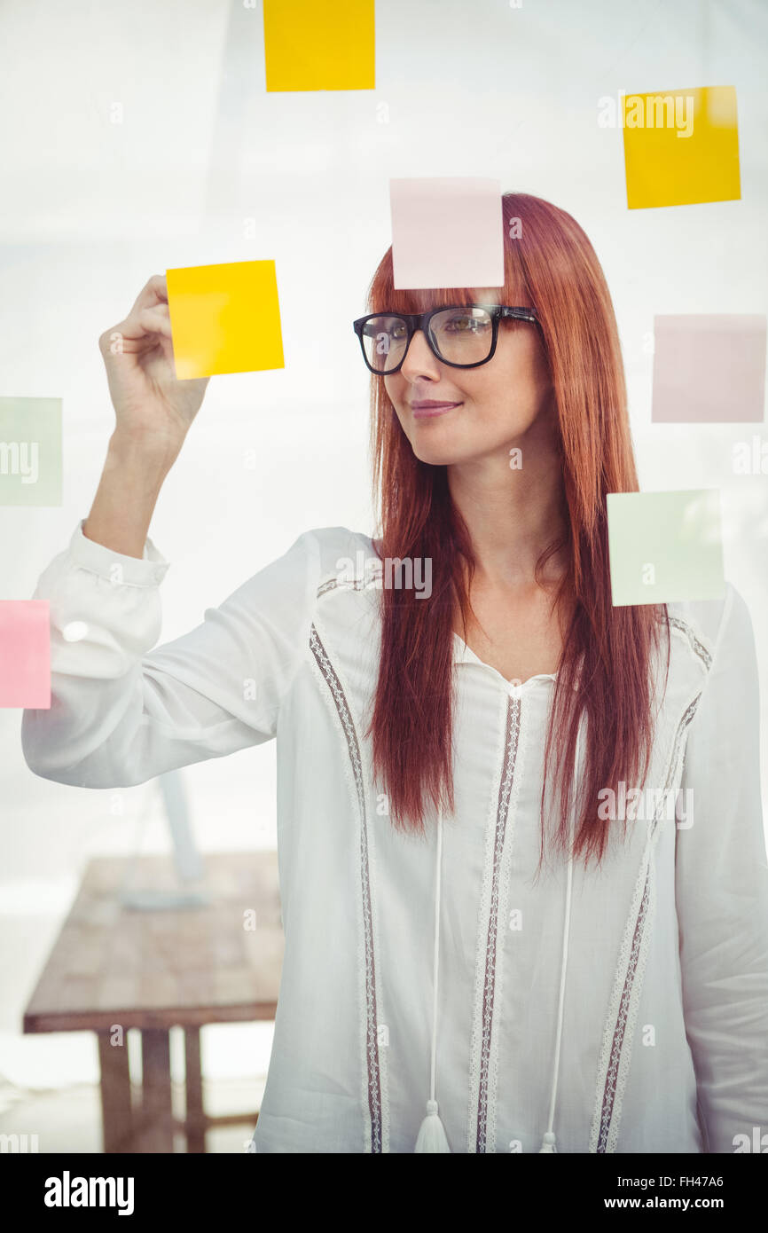 Attractive hipster woman writing on sticky notes Stock Photo - Alamy