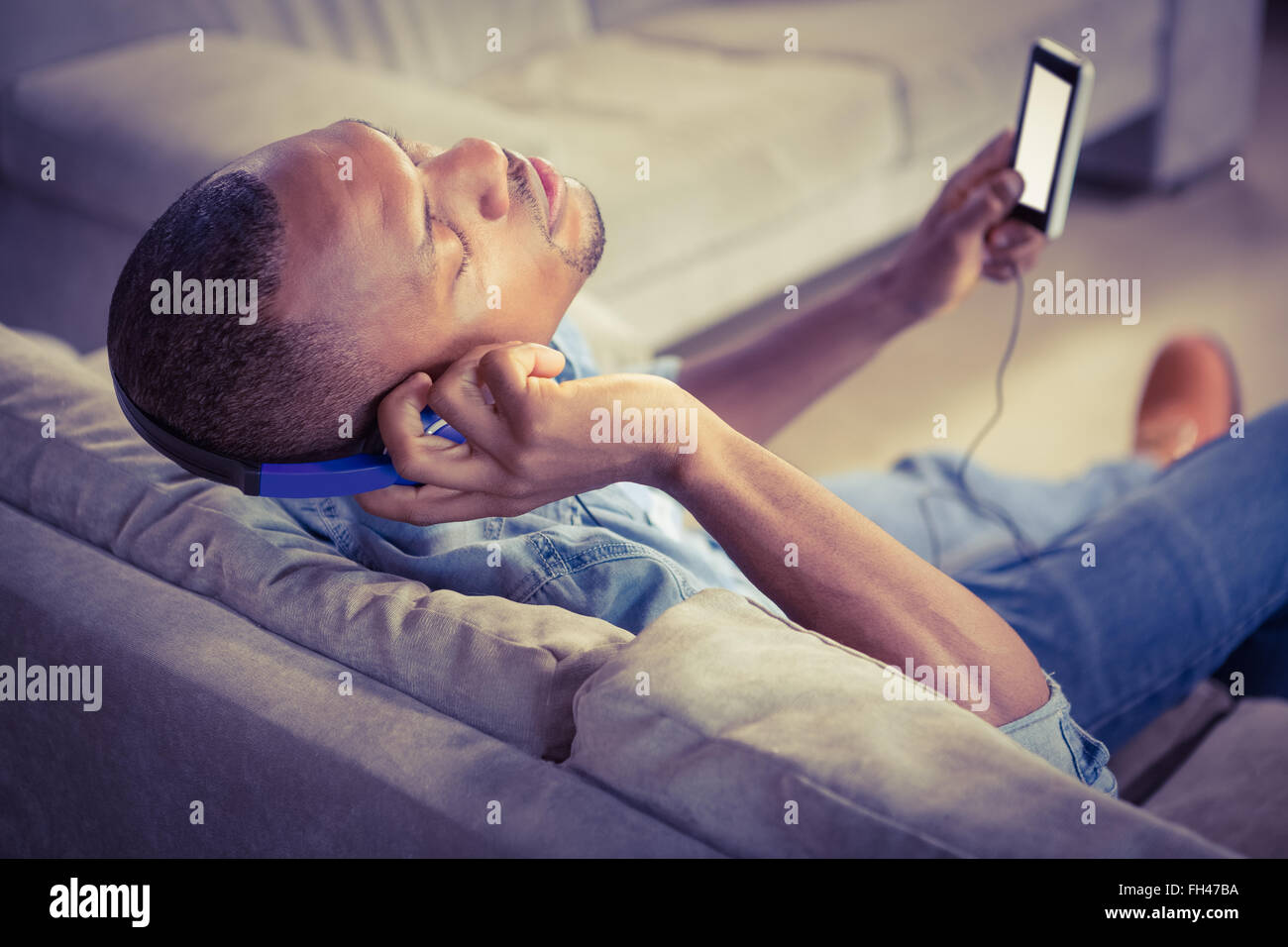 Over shoulder view of casual man listening music Stock Photo - Alamy