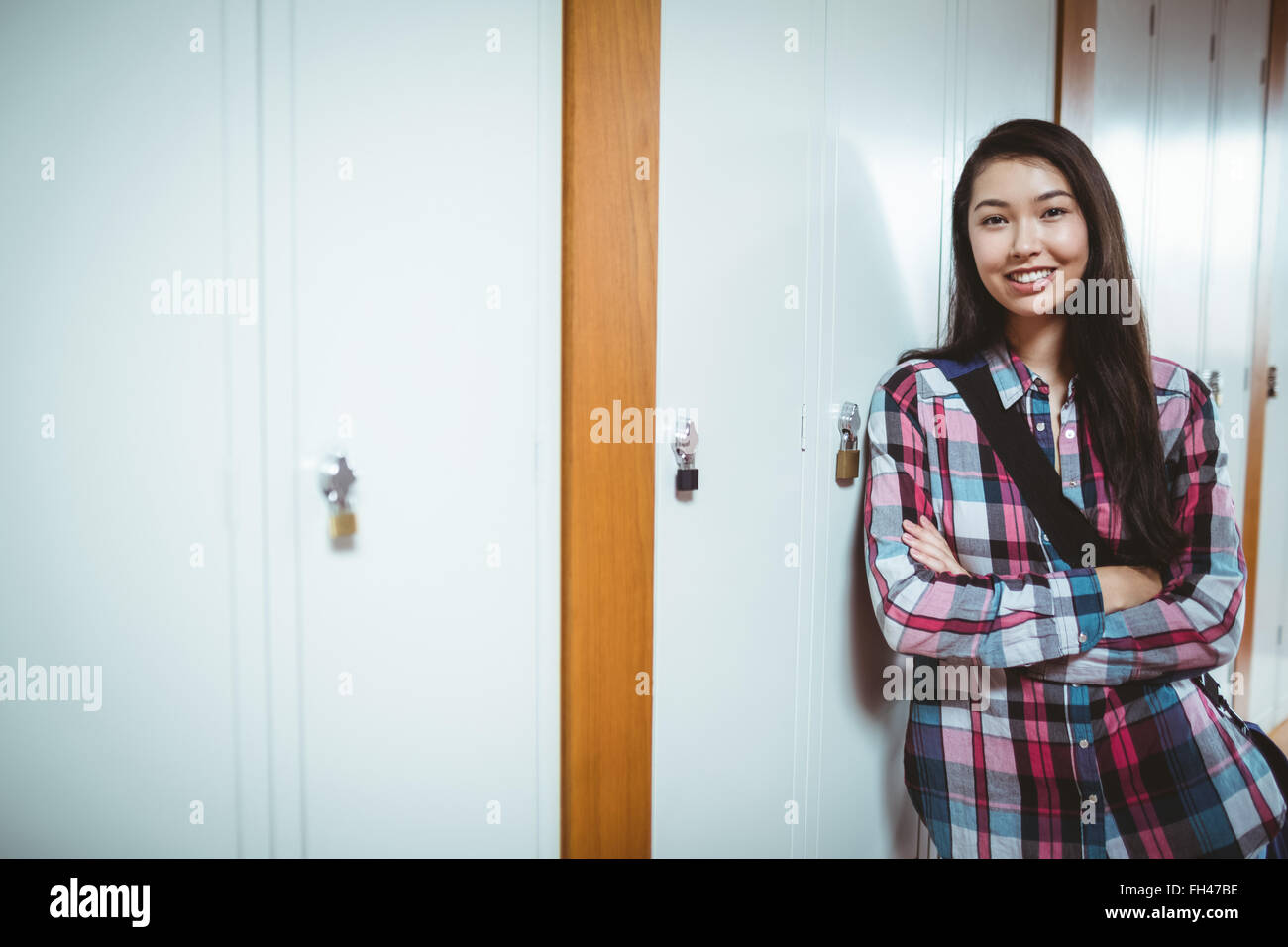 Cheerful student standing next the locker Stock Photo - Alamy