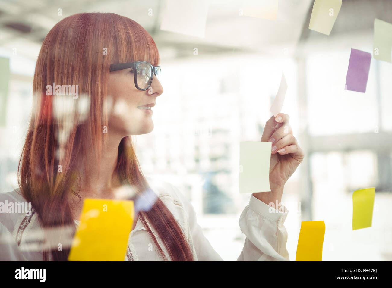 Attractive hipster woman looking at sticky notes Stock Photo - Alamy