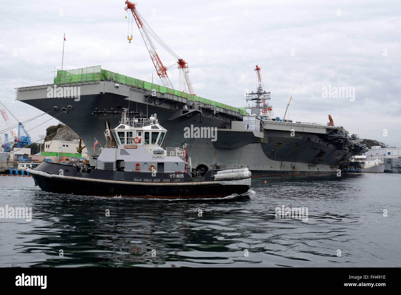 The Valiant-class tugboat USS Seminole (YT 805) passes the USS Ronald ...