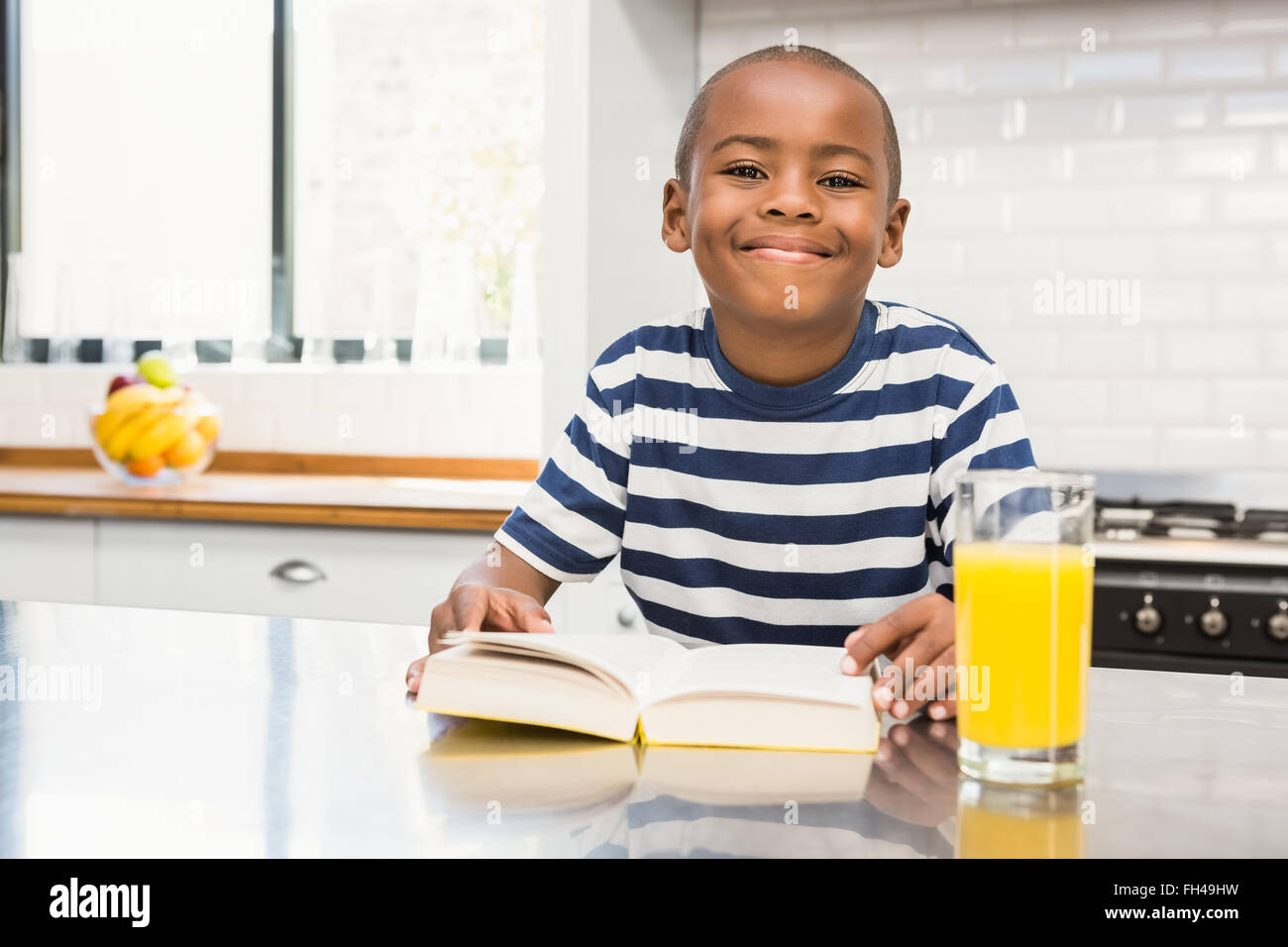 Smiling boy reading a book Stock Photo - Alamy
