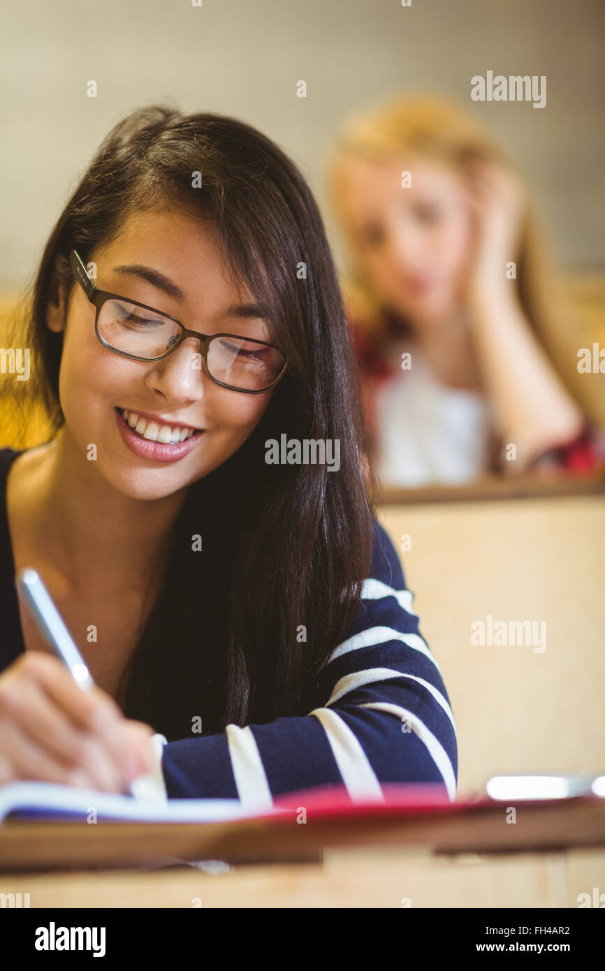 Smiling student writing on notebook Stock Photo - Alamy