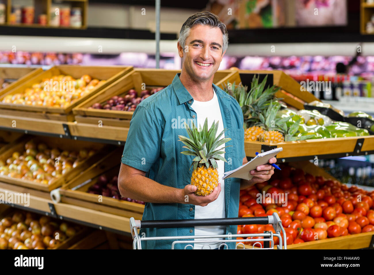 Smiling man looking at his list Stock Photo - Alamy