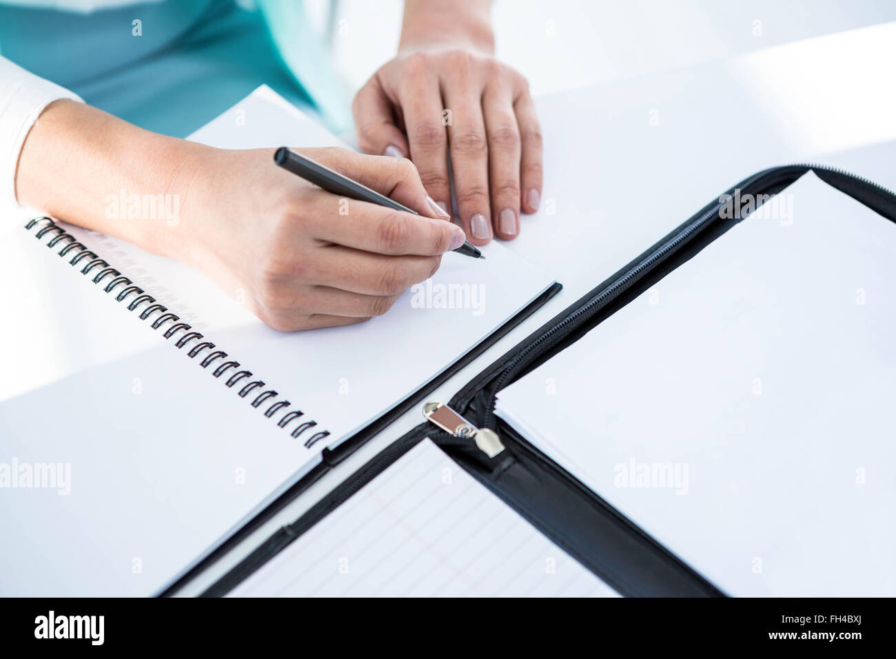 Businesswoman writing into notepad Stock Photo - Alamy
