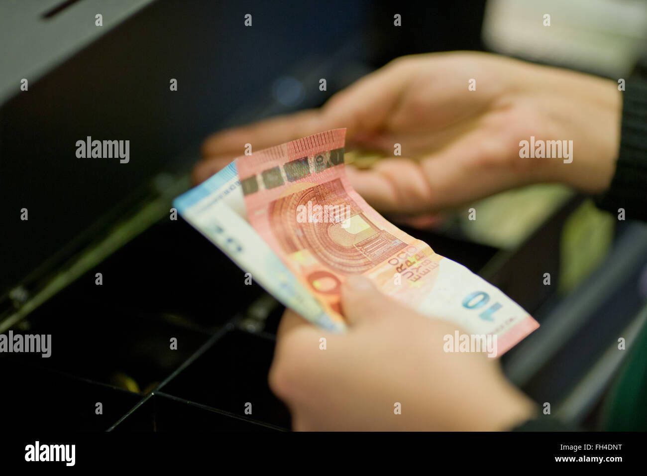 Nuremberg, Germany. 4th Feb, 2016. A cashier in a supermarket counts ...