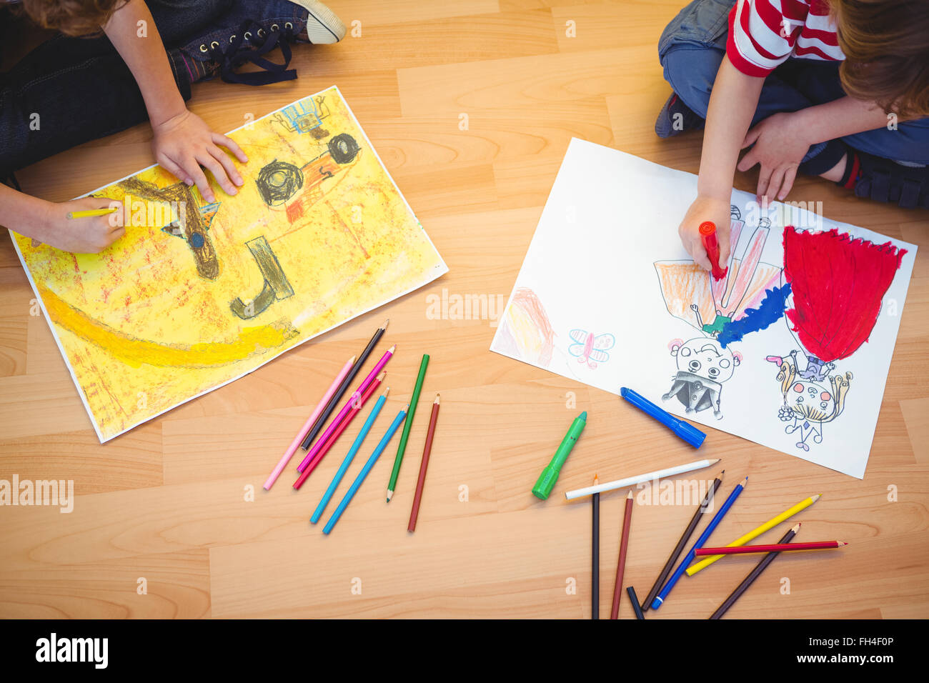 Two kids drawing together on sheets Stock Photo - Alamy