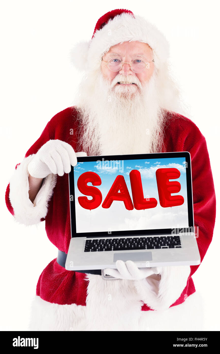 Composite image of santa claus presents a laptop Stock Photo - Alamy