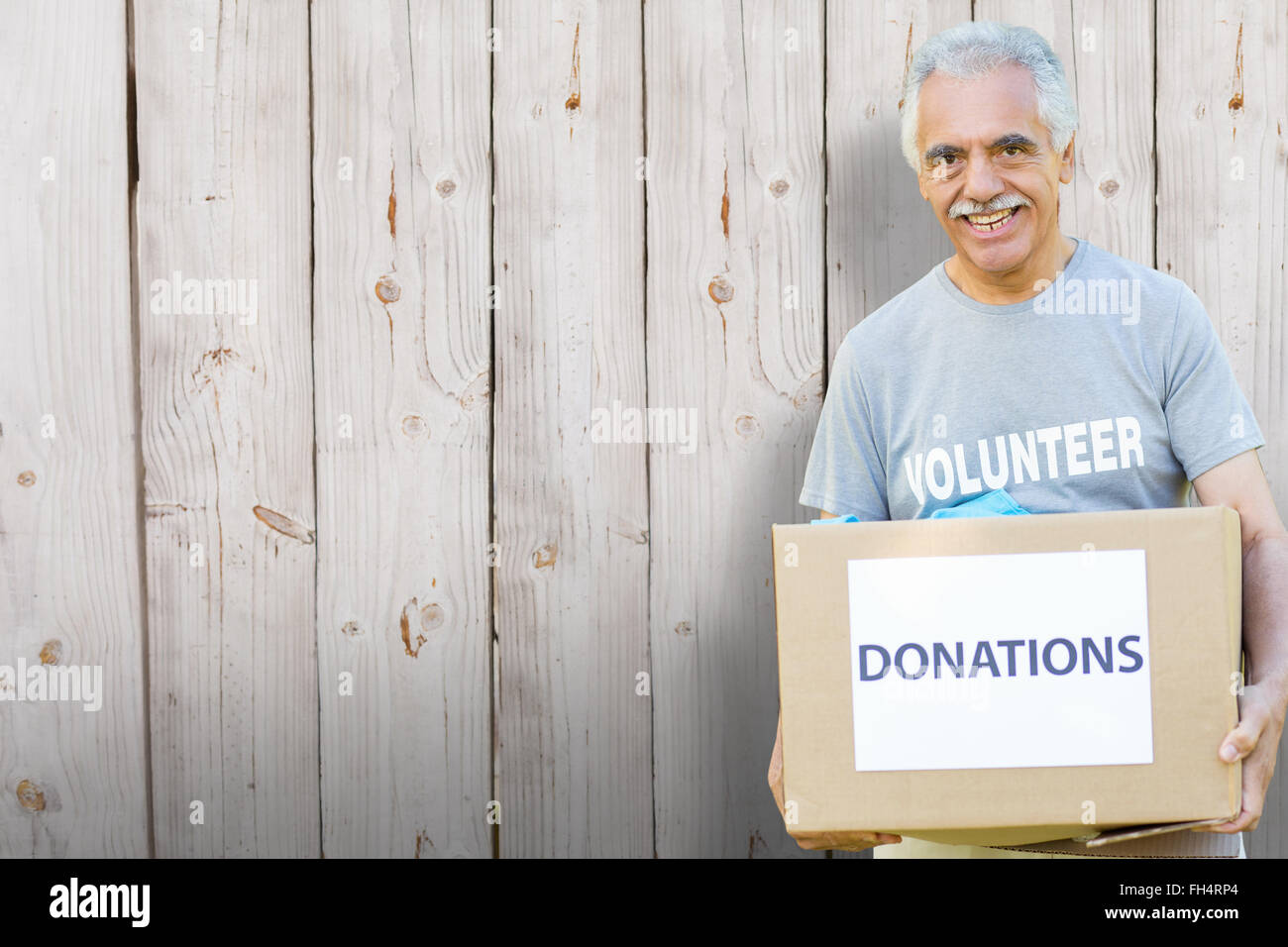 Composite image of happy volunteer senior holding donation box Stock ...