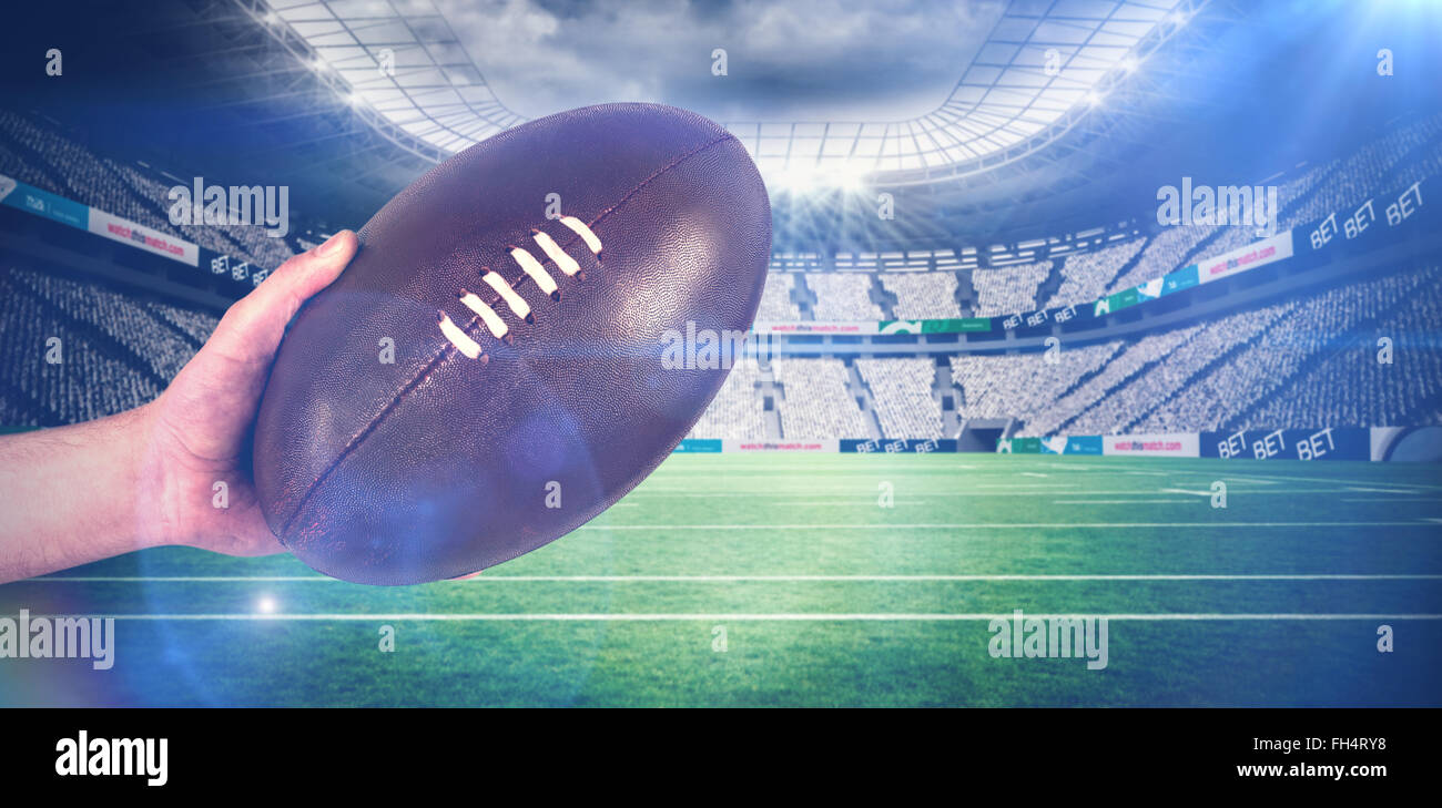 Composite image of rugby player handing a rugby ball Stock Photo - Alamy
