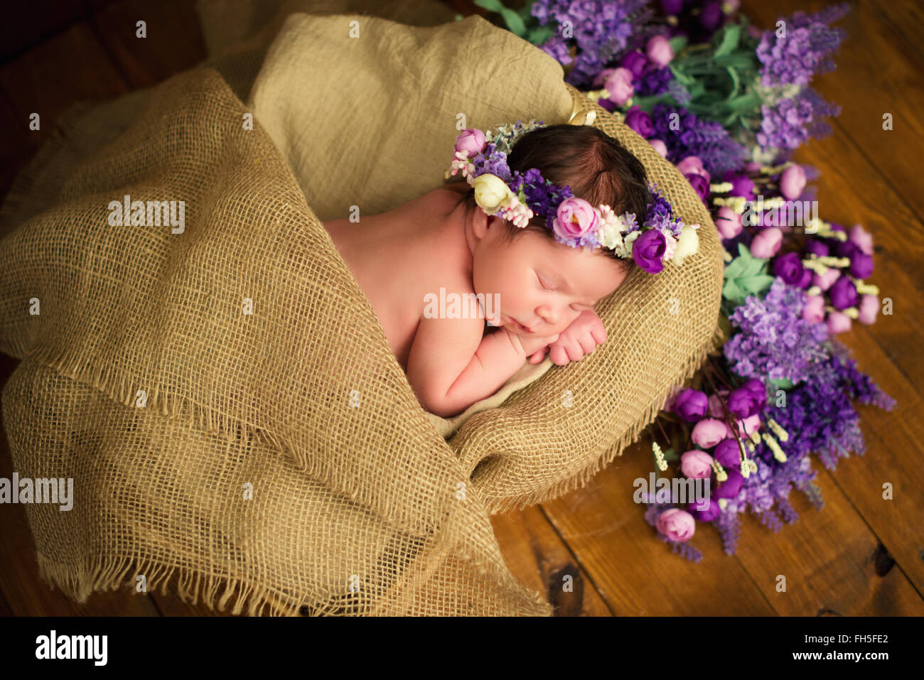Sweet dreams of newborn baby. Beautiful little girl with lilac flowers ...
