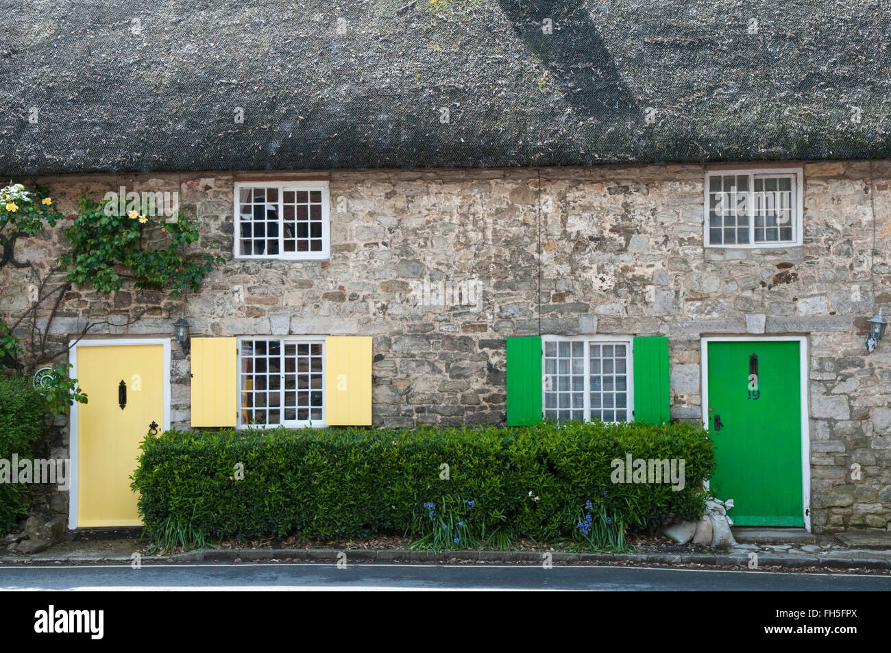 Two traditional stone built thatched cottages with painted green and ...