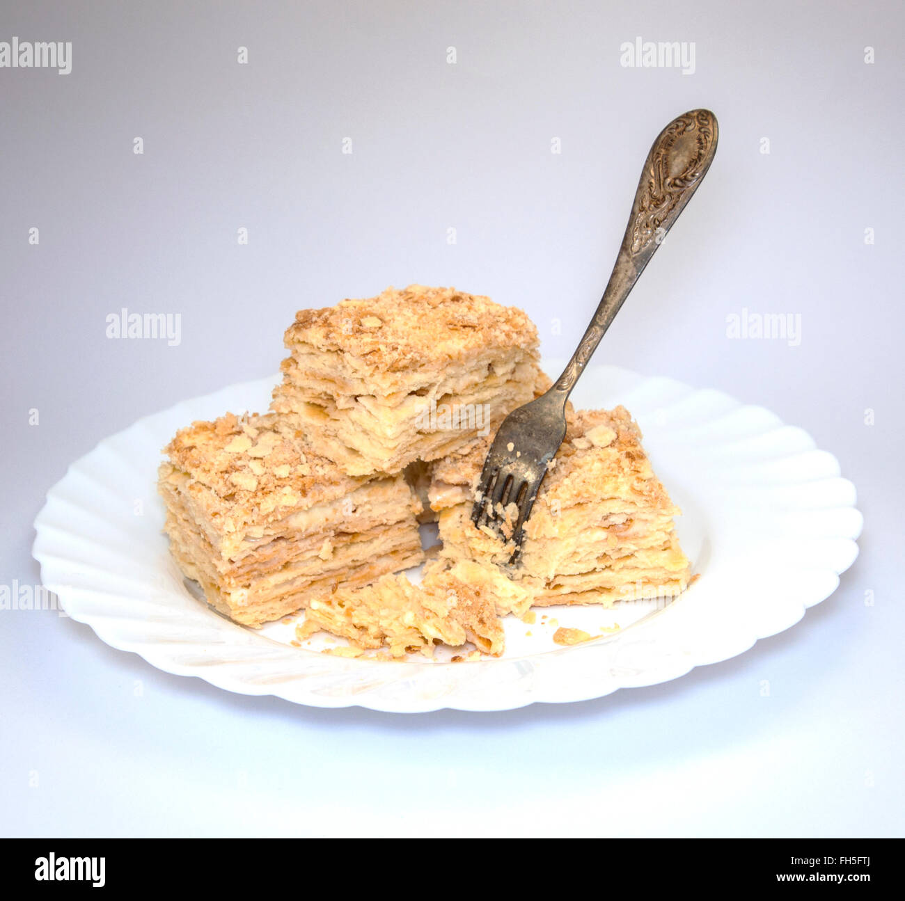 The process of eating the cake pieces on a white background on a plate ...