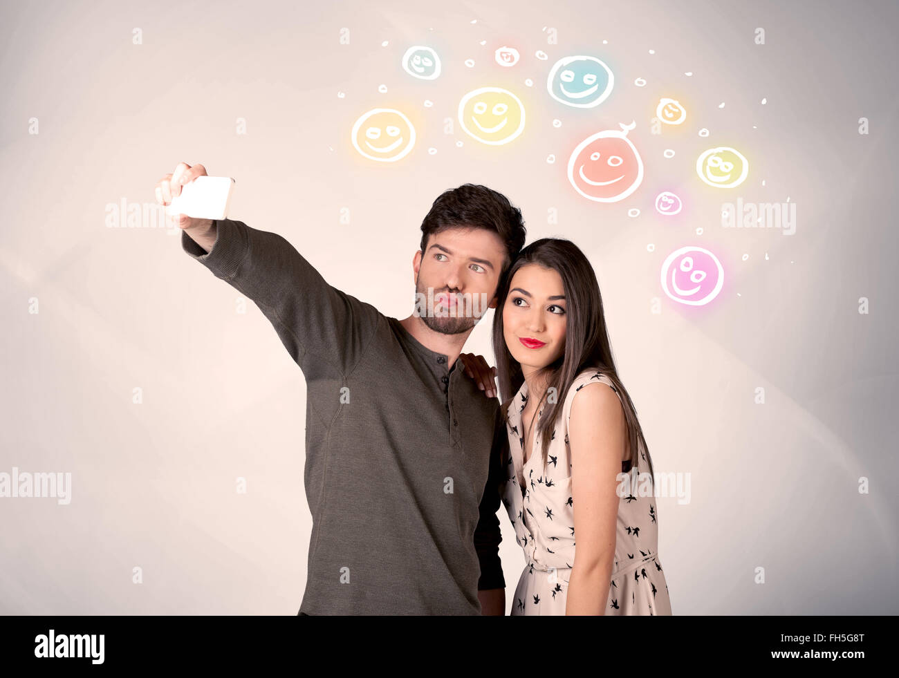 Happy couple taking selfie with smiley Stock Photo - Alamy