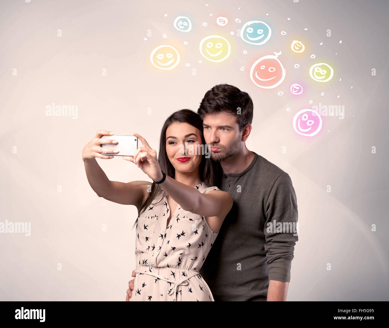 Happy couple taking selfie with smiley Stock Photo - Alamy