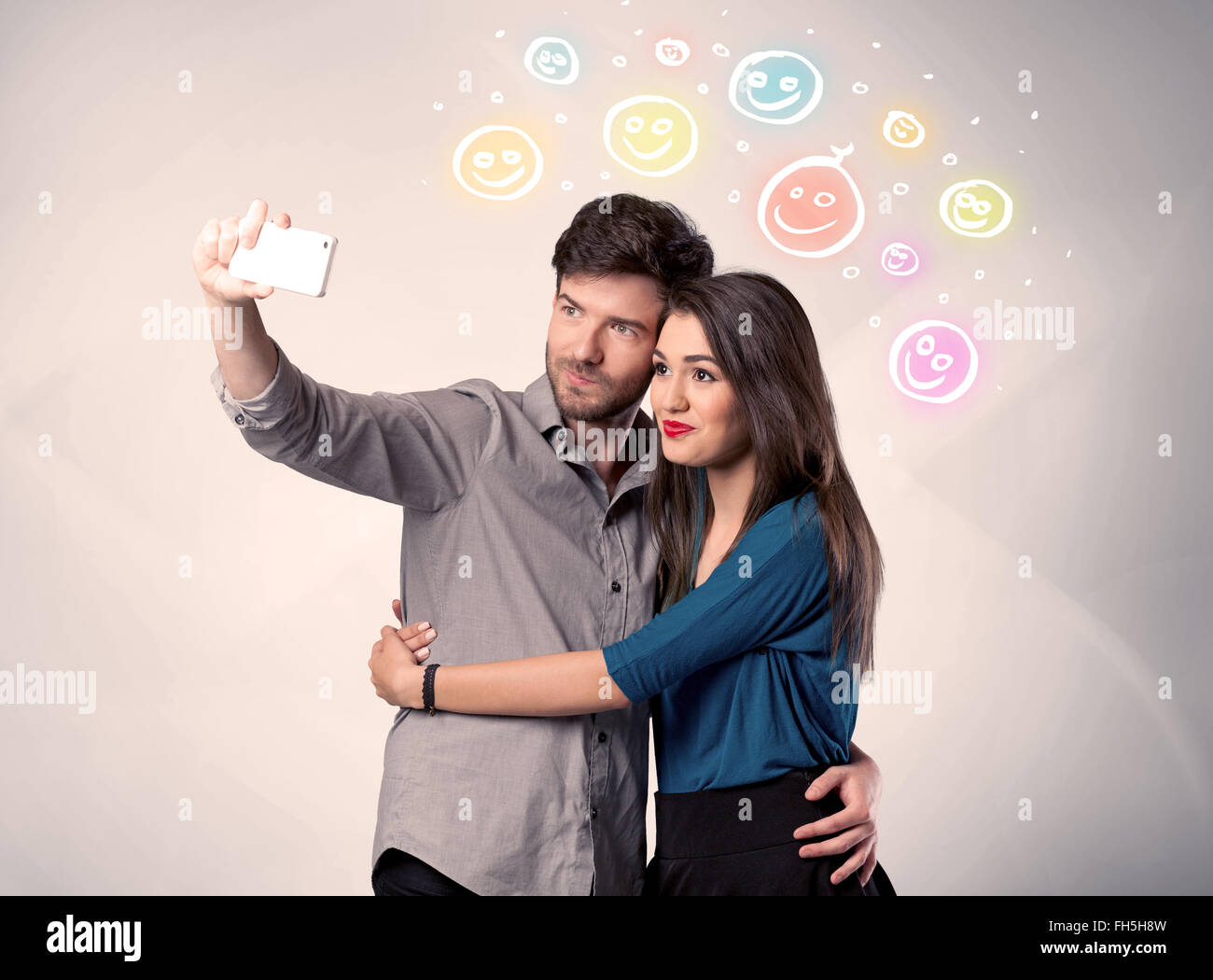 Happy couple taking selfie with smiley Stock Photo - Alamy