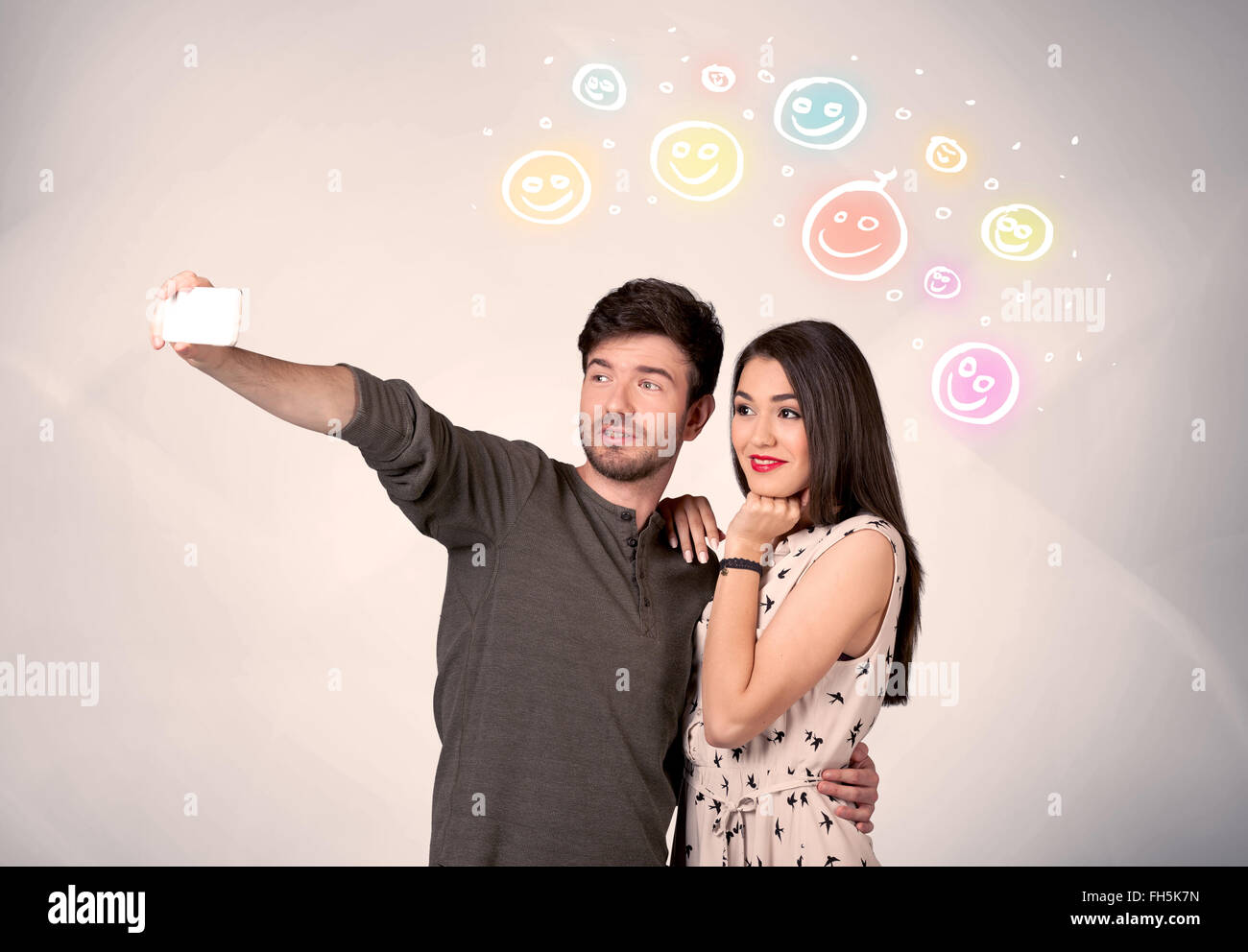 Happy couple taking selfie with smiley Stock Photo - Alamy
