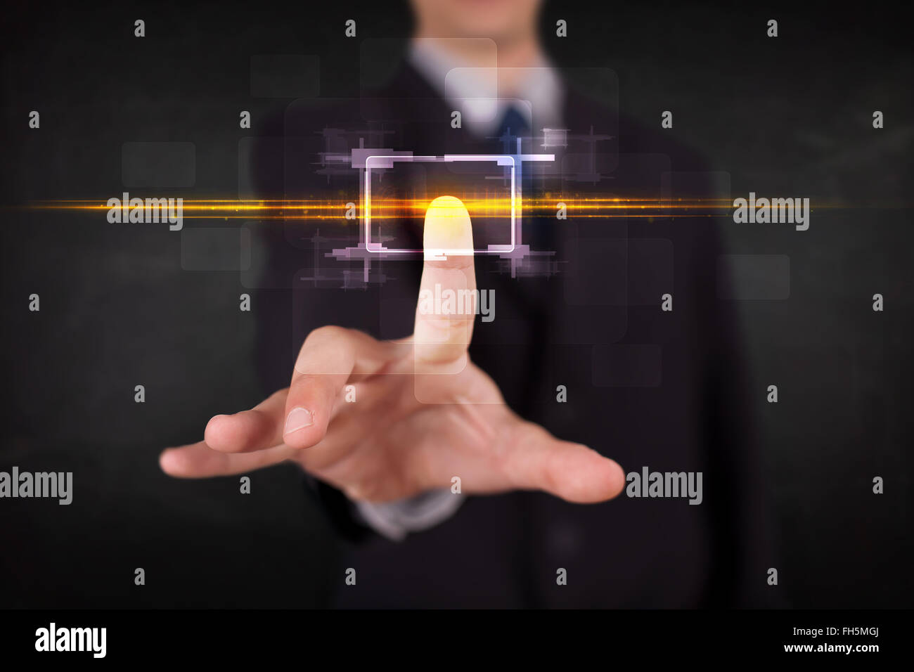 Tech business person touching button with orange light beams concept ...