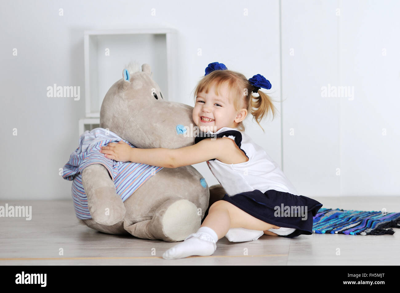 Little girl hugging a teddy hippo in studio Stock Photo - Alamy