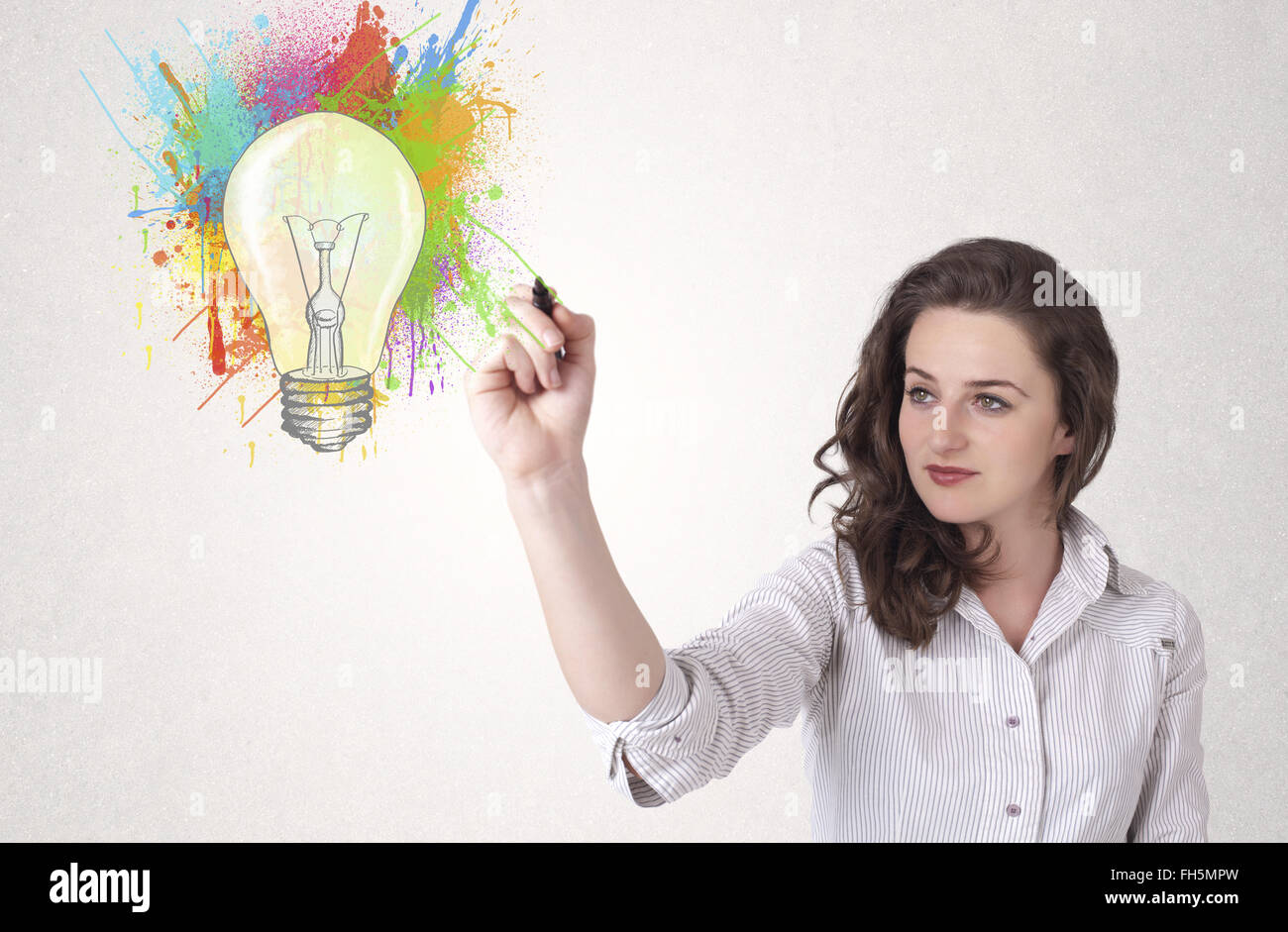 Young lady drawing a colorful light bulb with colorful splashes Stock ...