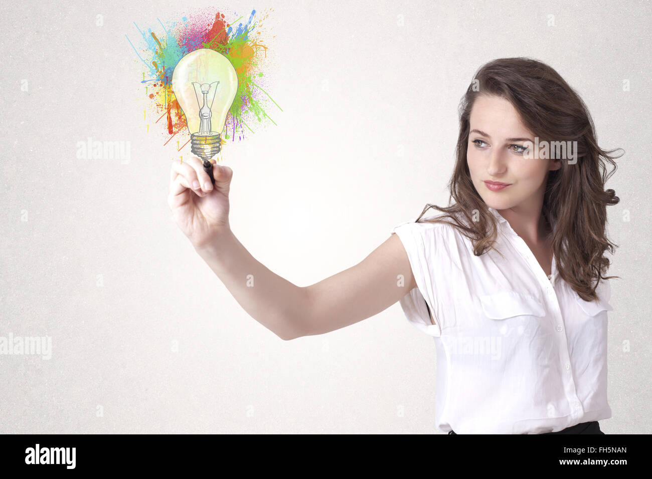 Young lady drawing a colorful light bulb with colorful splashes Stock ...