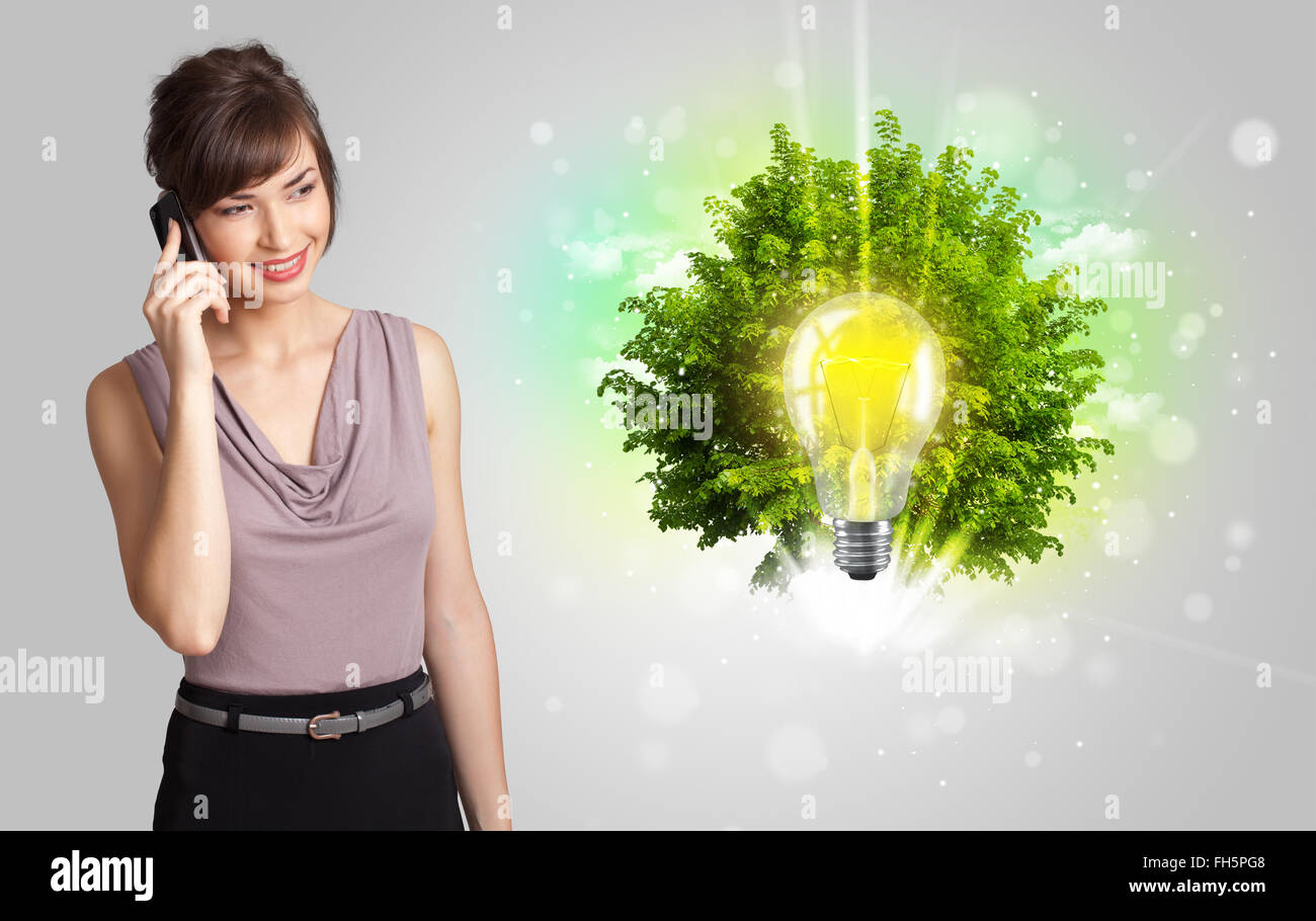 Young girl presenting idea light bulb with green tree Stock Photo - Alamy