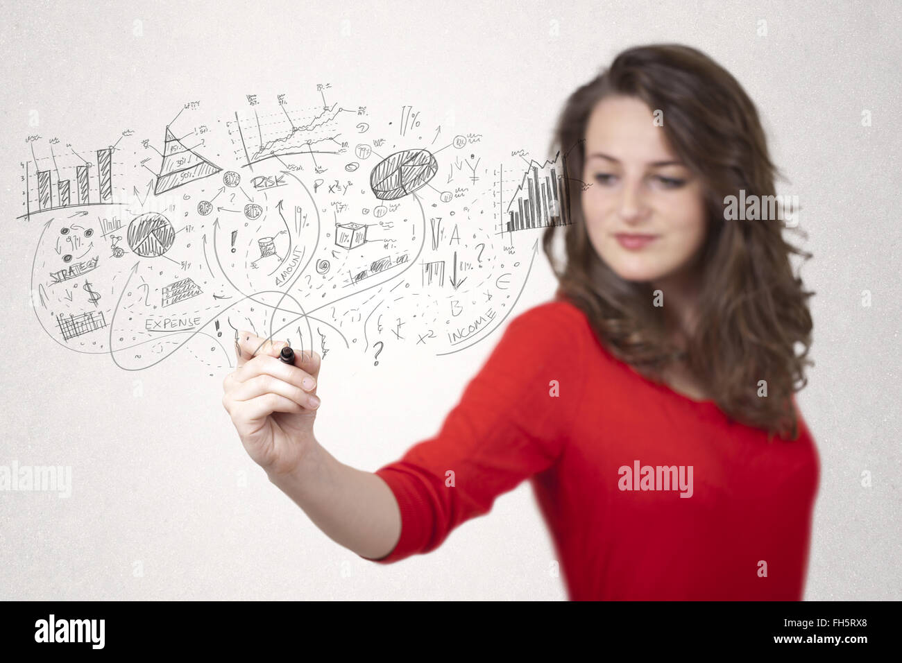 Pretty girl sketching graphs and diagrams on wall Stock Photo - Alamy