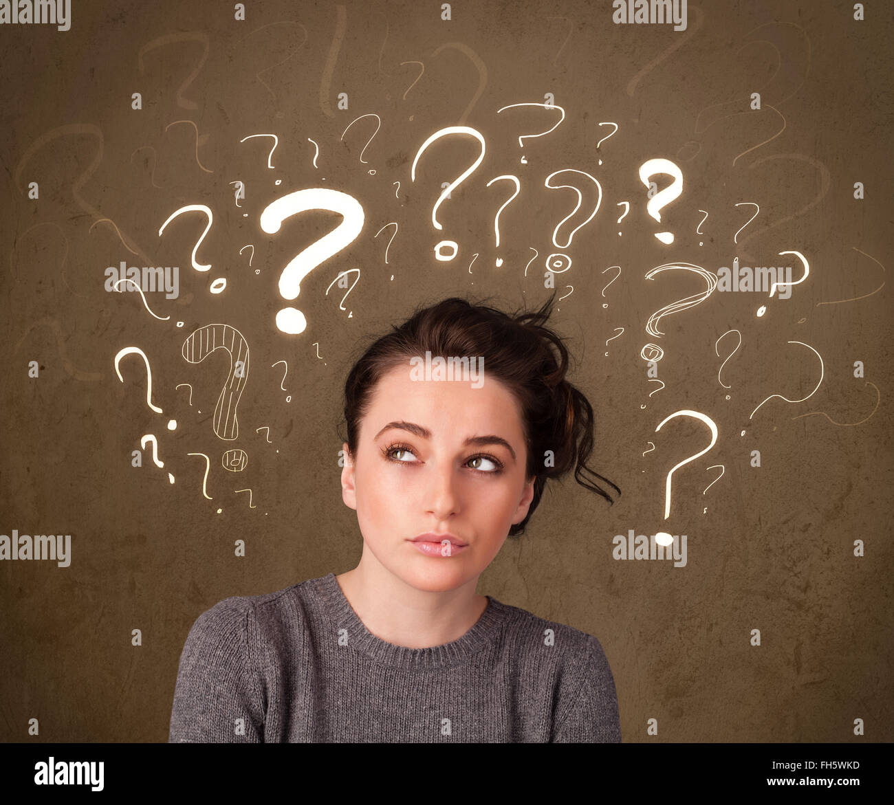girl with question mark symbols around her head Stock Photo - Alamy