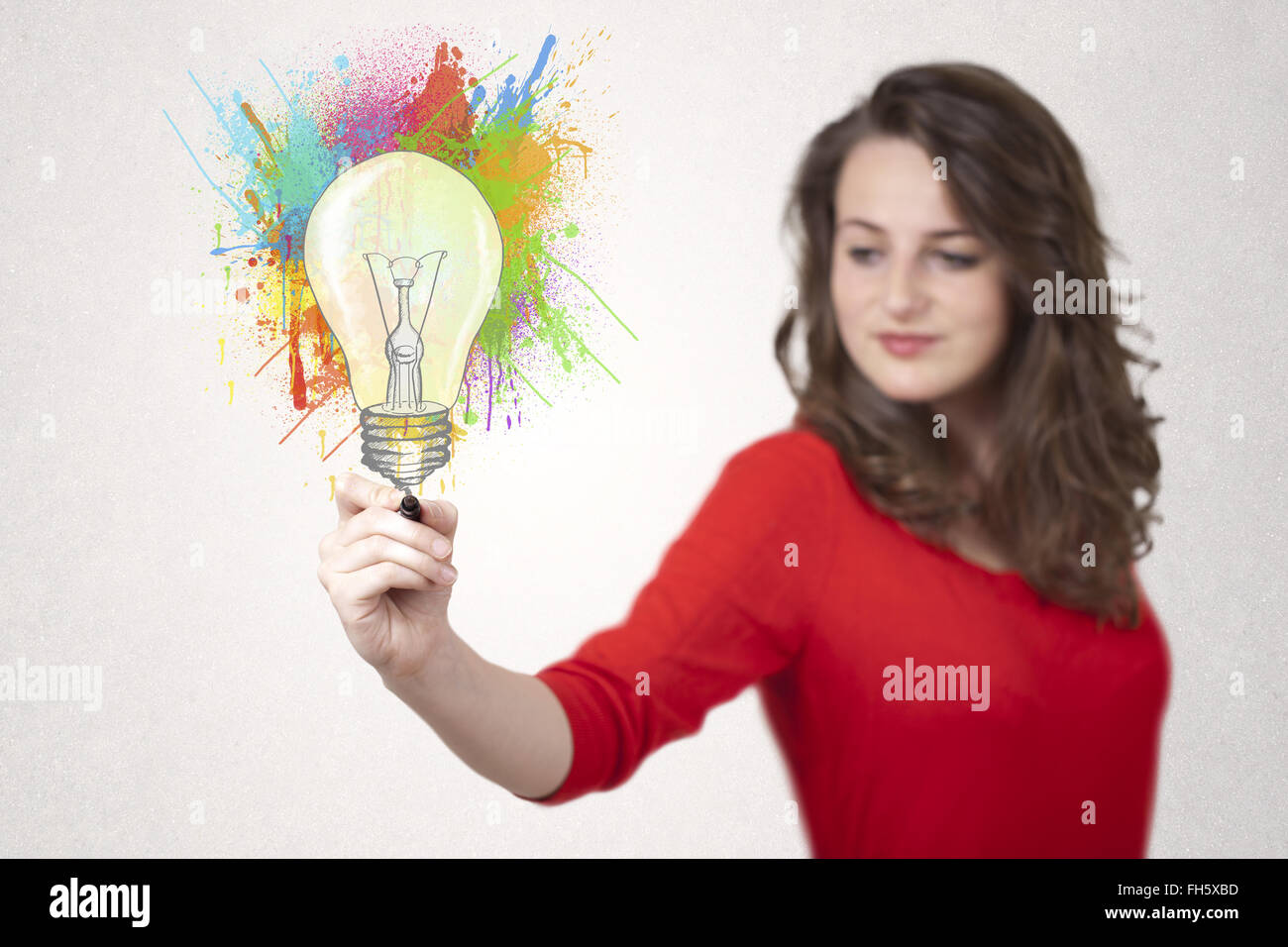 Young lady drawing a colorful light bulb with colorful splashes Stock ...