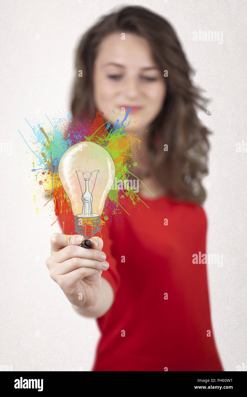 Young lady drawing a colorful light bulb with colorful splashes Stock ...