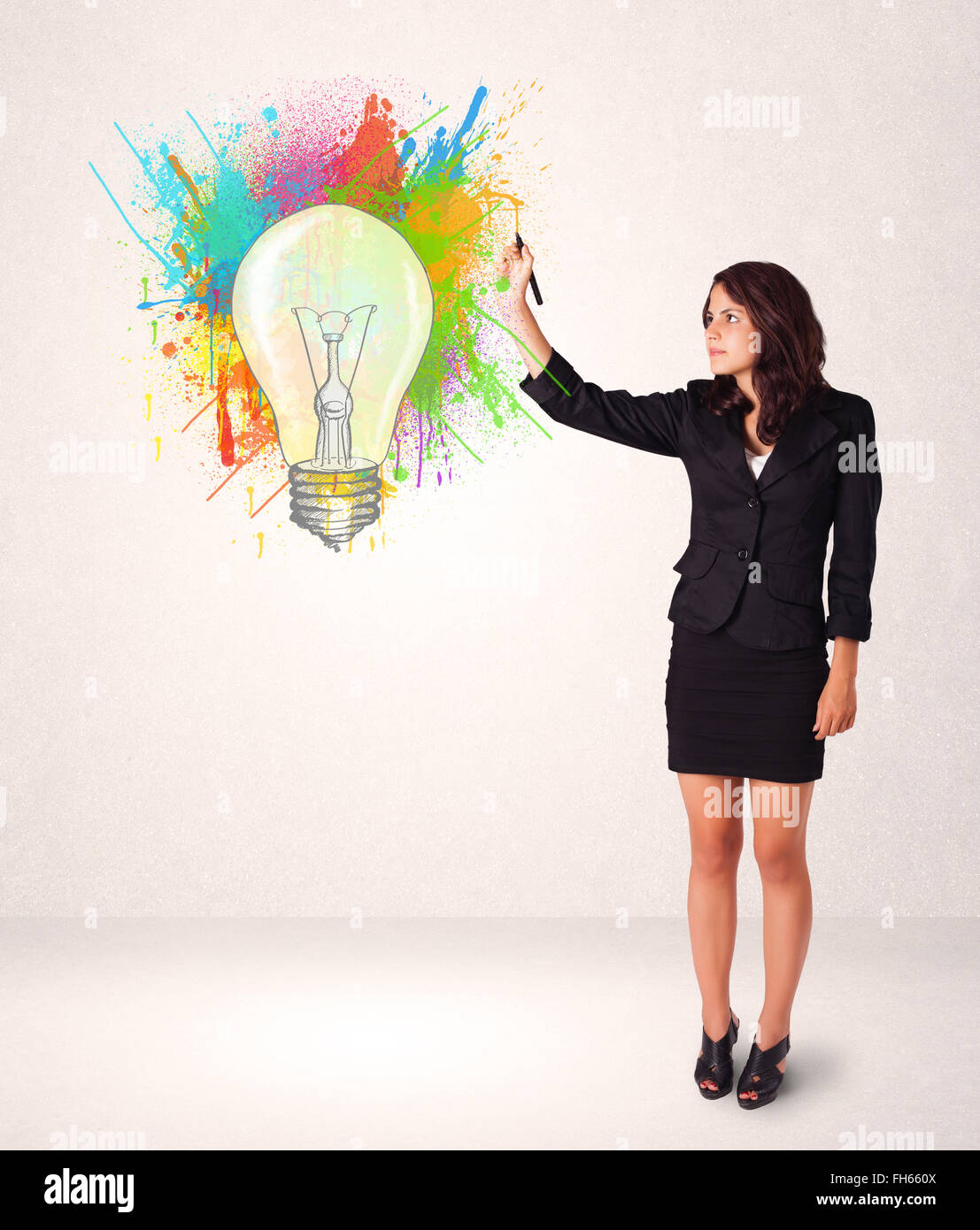 Young lady drawing a colorful light bulb with colorful splashes Stock ...