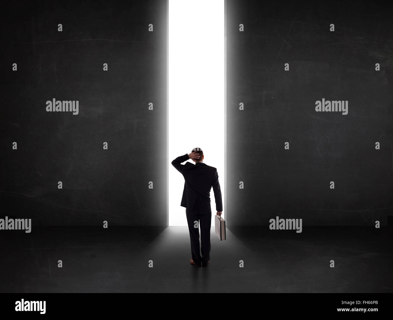 Business person looking at wall with light tunnel opening Stock Photo ...