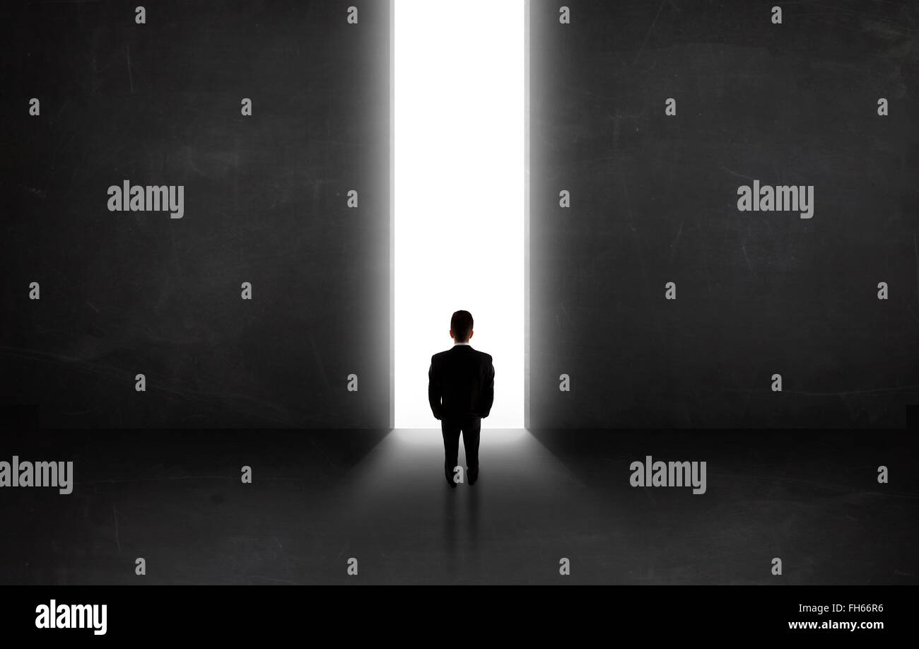Business person looking at wall with light tunnel opening Stock Photo ...