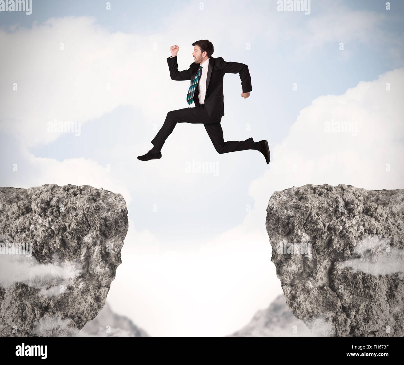 Funny business man jumping over rocks with gap Stock Photo - Alamy
