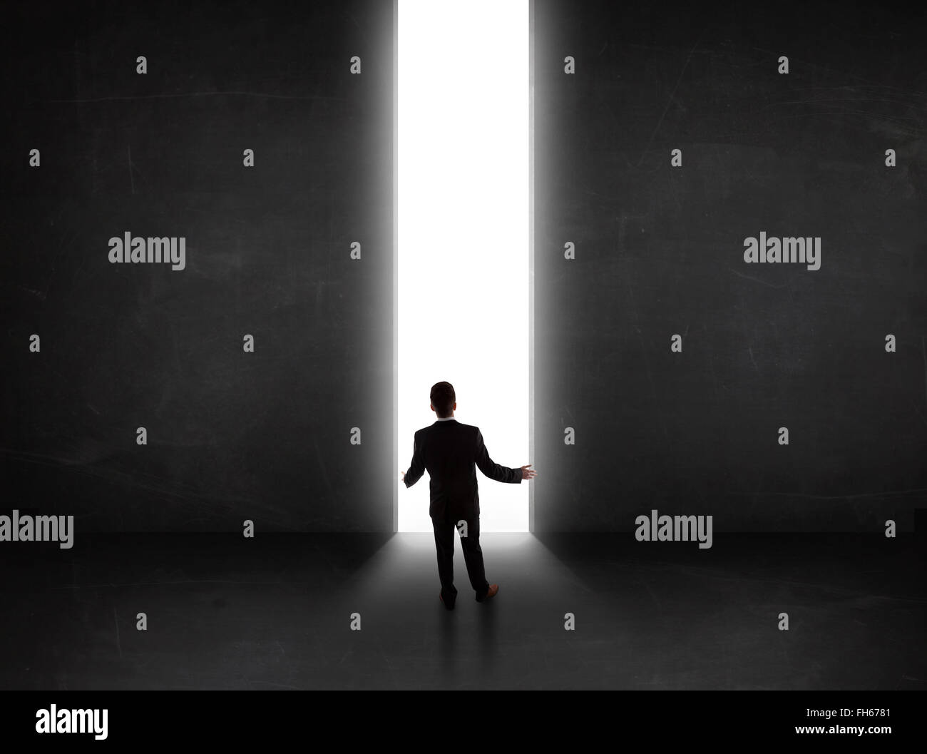 Business person looking at wall with light tunnel opening Stock Photo ...
