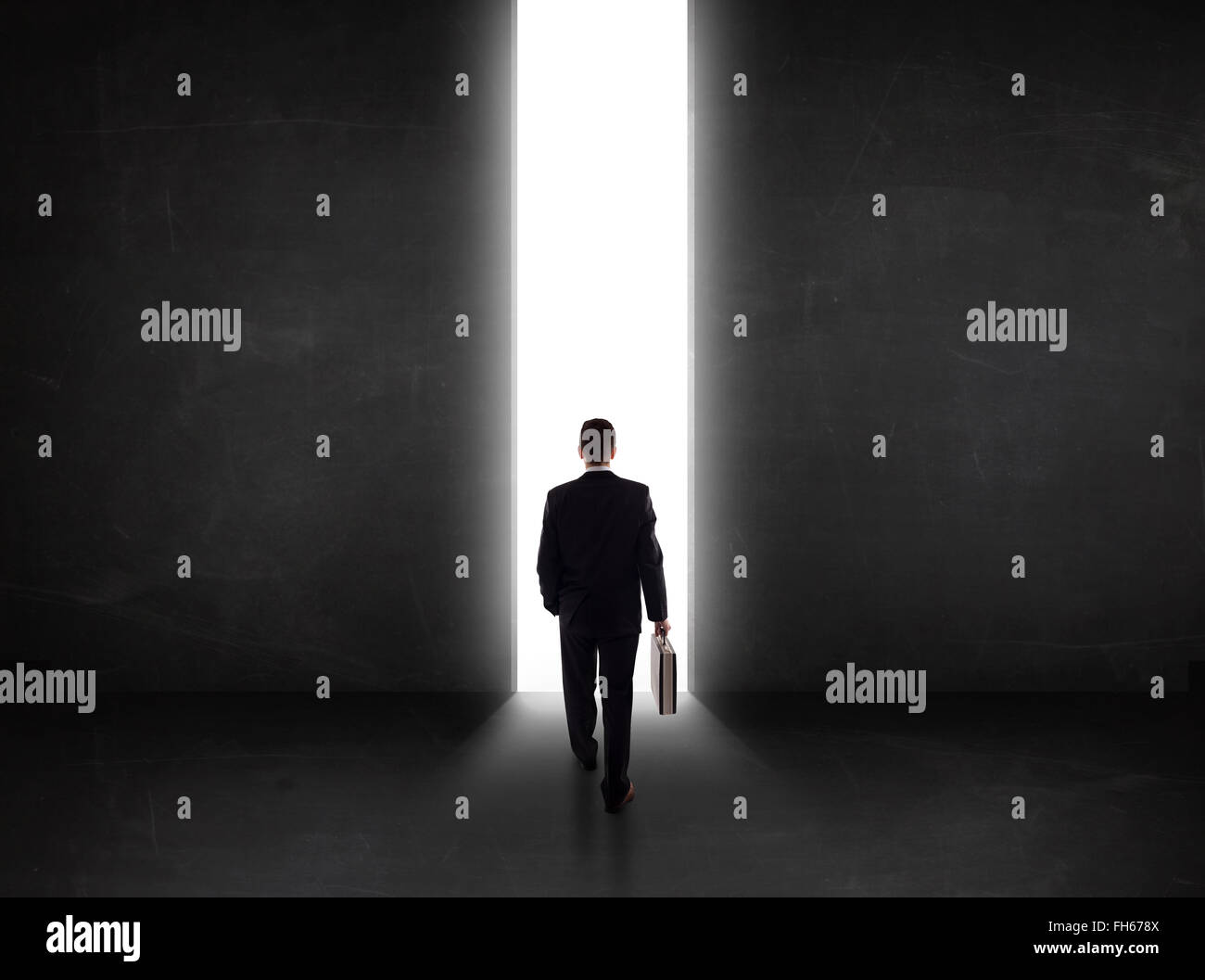 Business person looking at wall with light tunnel opening Stock Photo ...