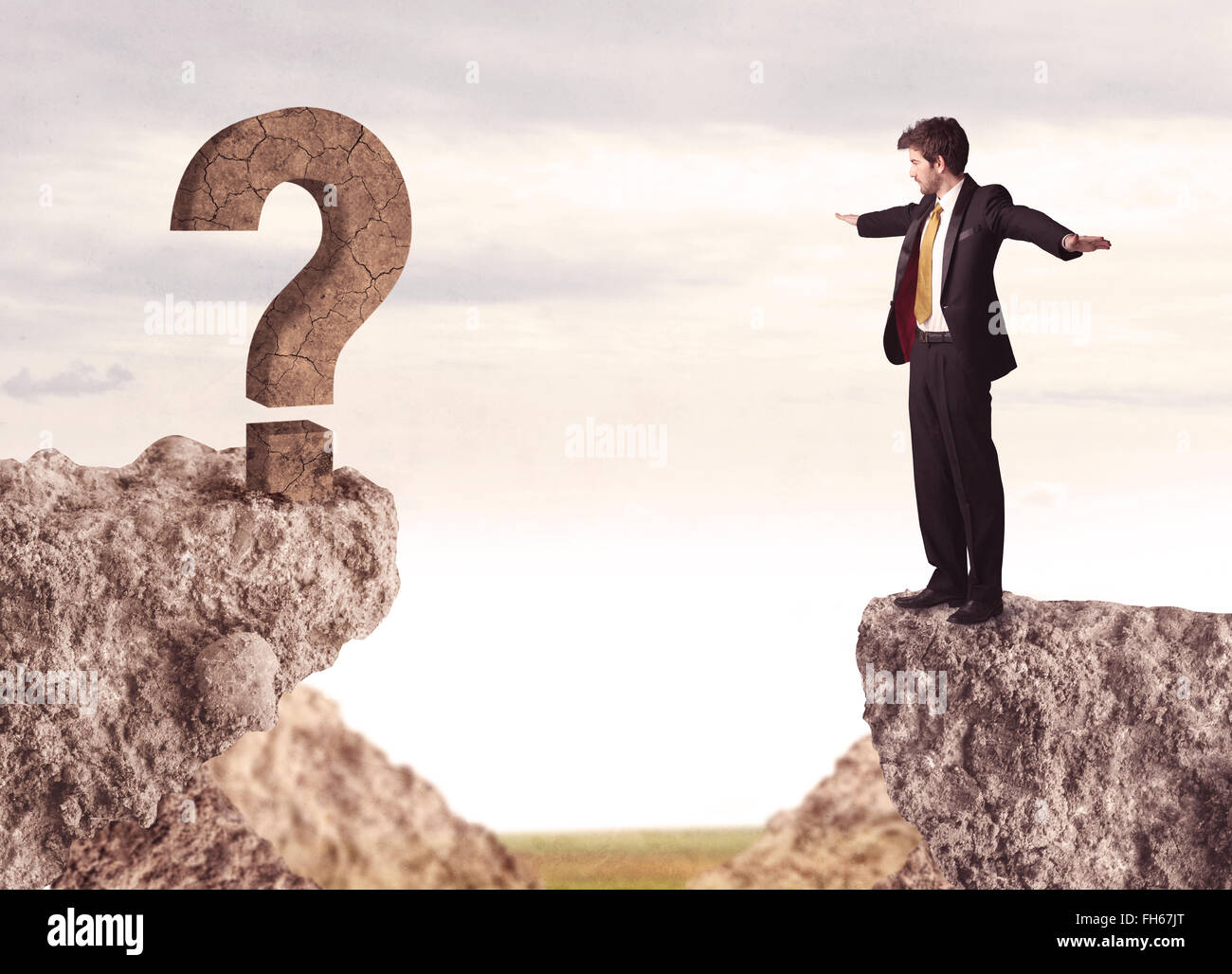Businessman on rock mountain with a question mark Stock Photo - Alamy