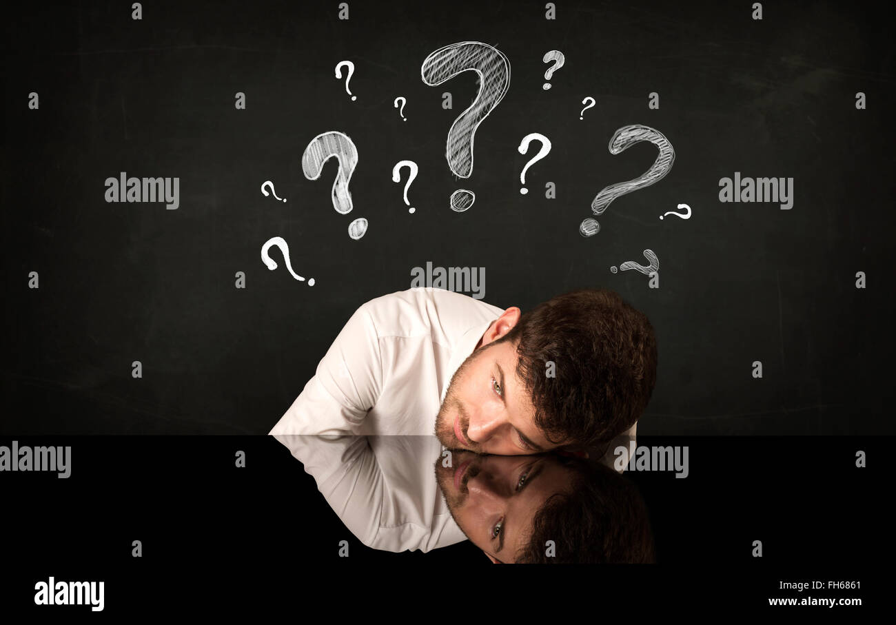 Sitting businessman under question marks Stock Photo - Alamy