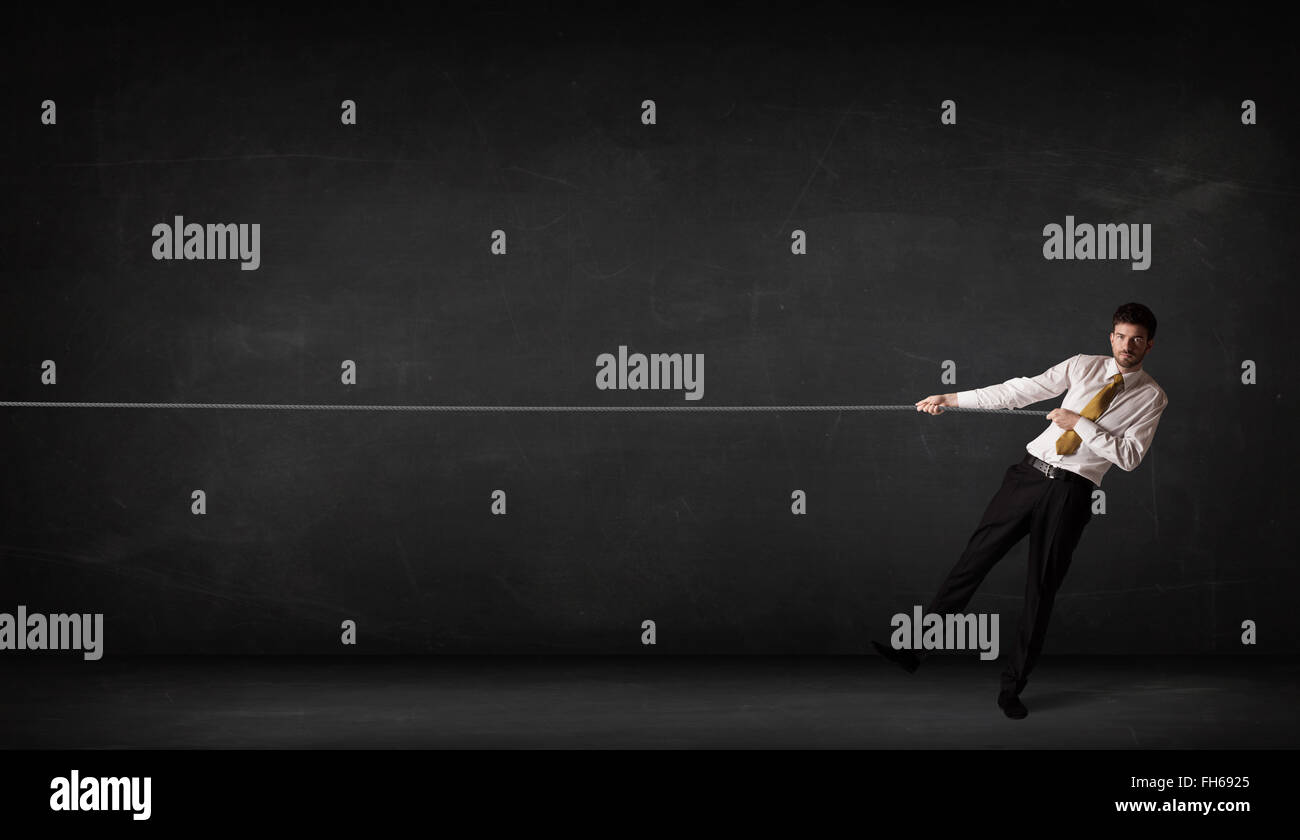 Businessman pulling rope on grey background Stock Photo - Alamy