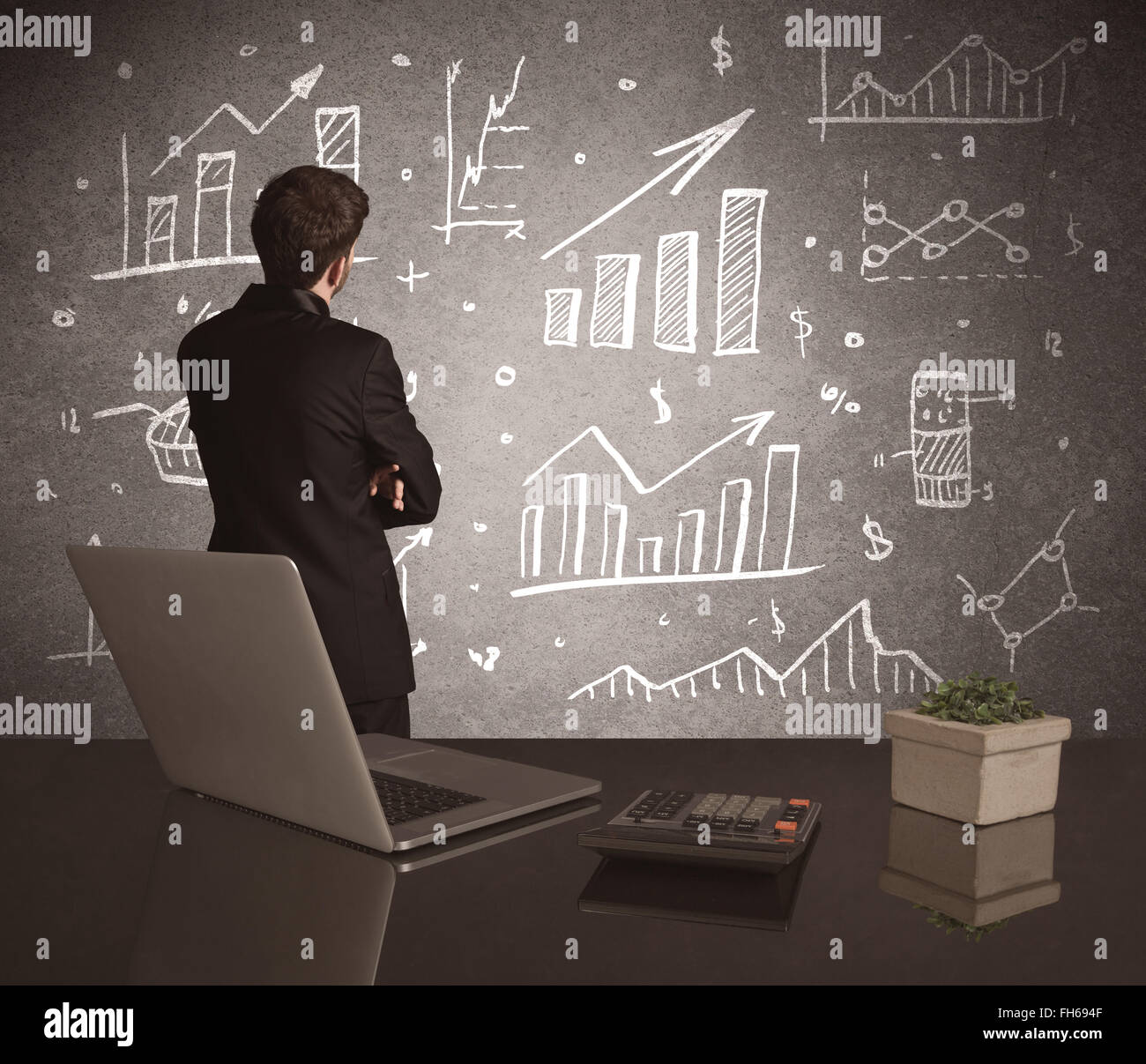 Businessman drawing sales charts on wall Stock Photo - Alamy
