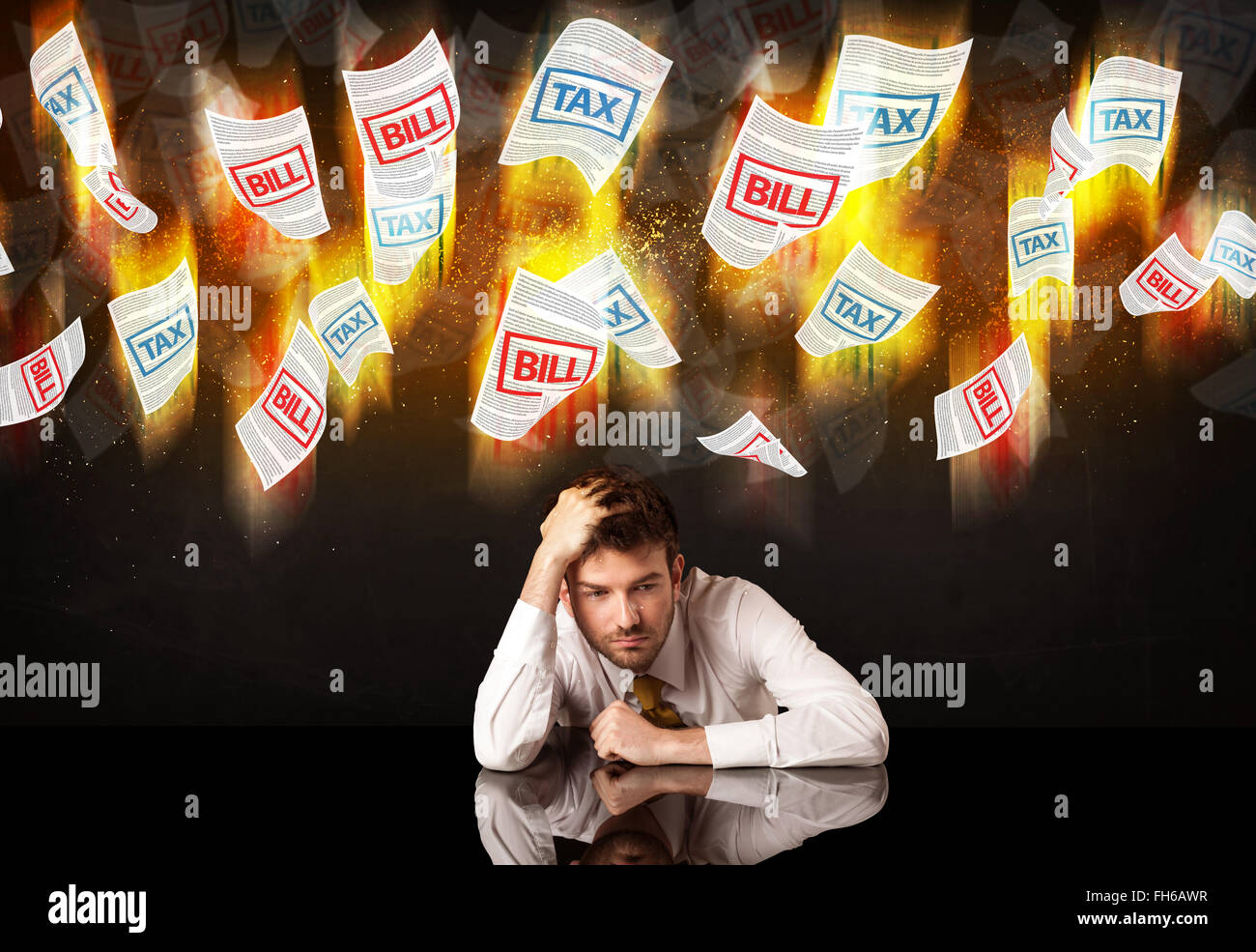 Depressed businessman sitting under burning tax and bill papers Stock ...