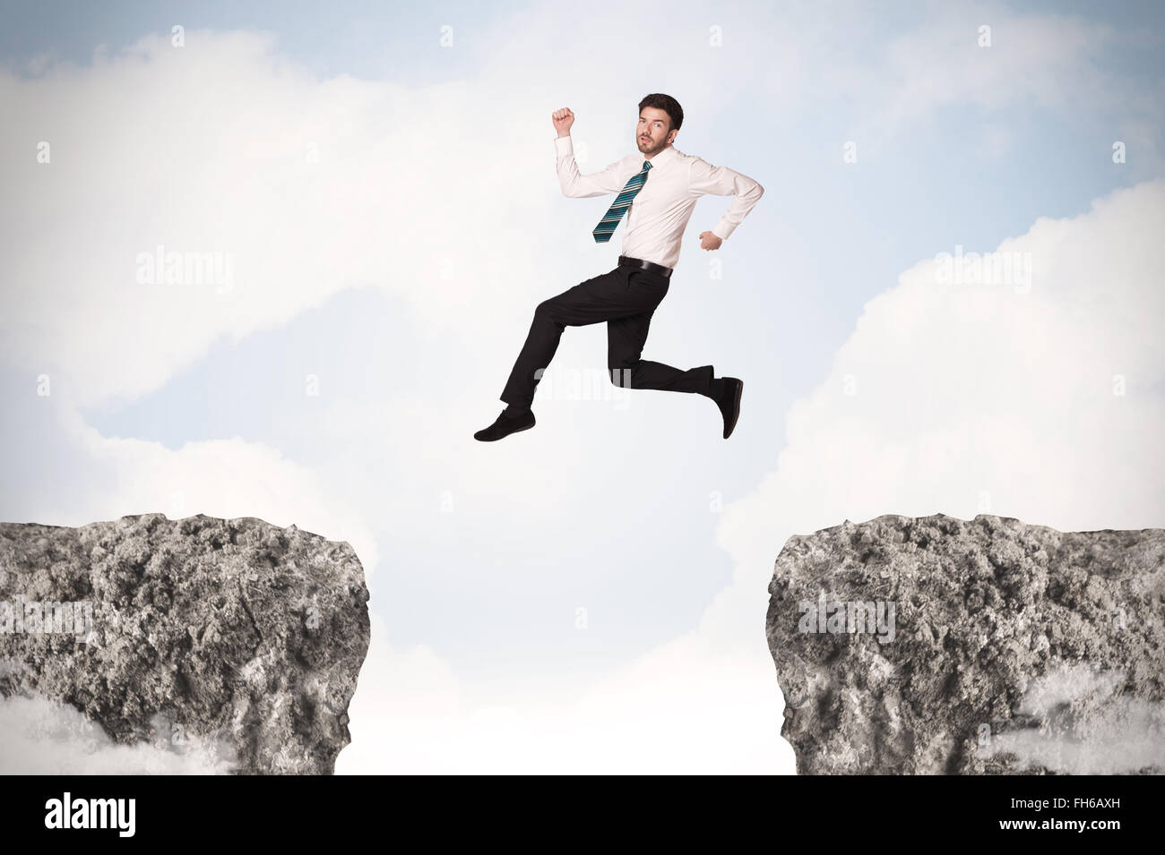 Funny business man jumping over rocks with gap Stock Photo - Alamy